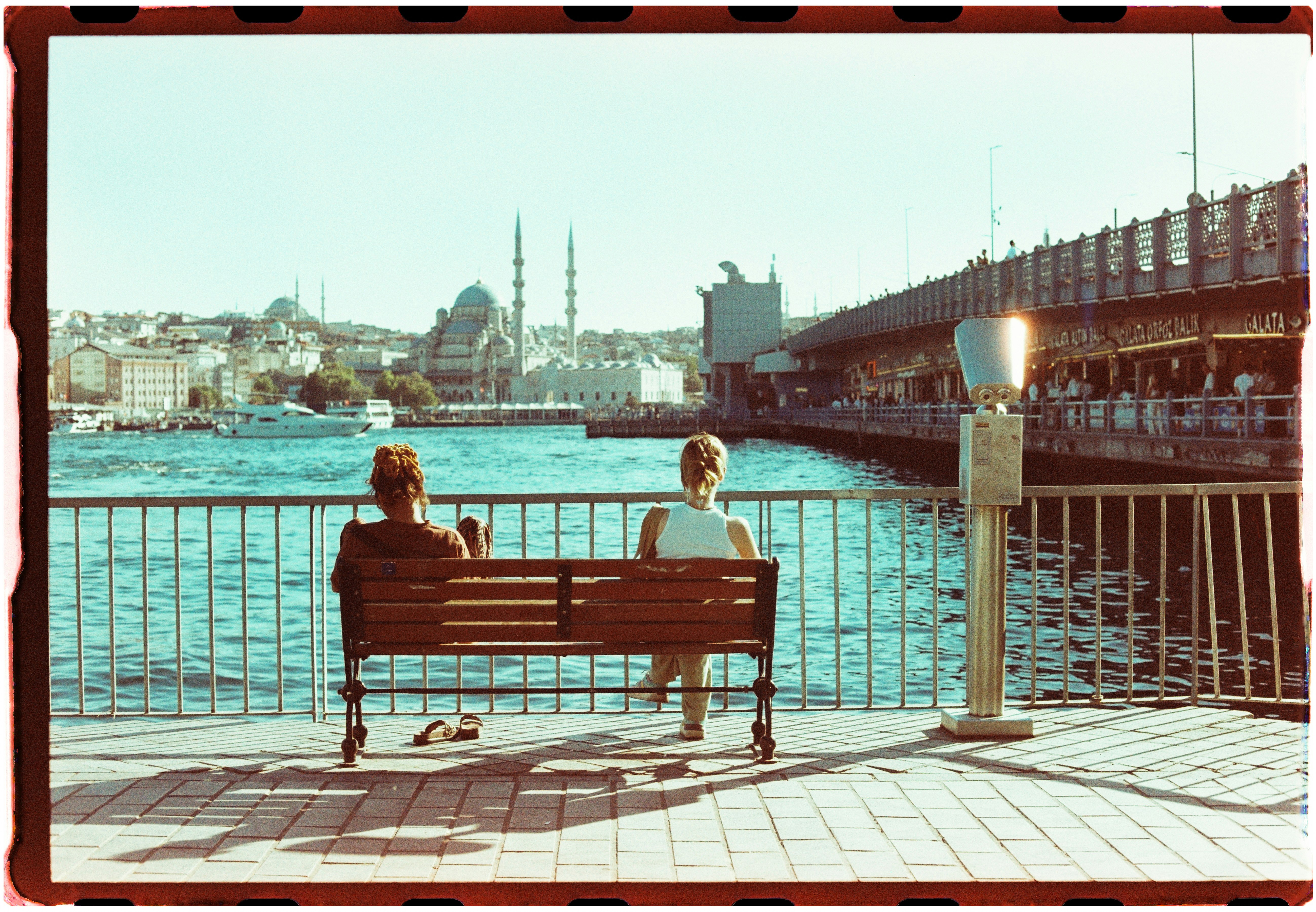Quiet Riverside Pause: Two Friends on a Waterfront Bench