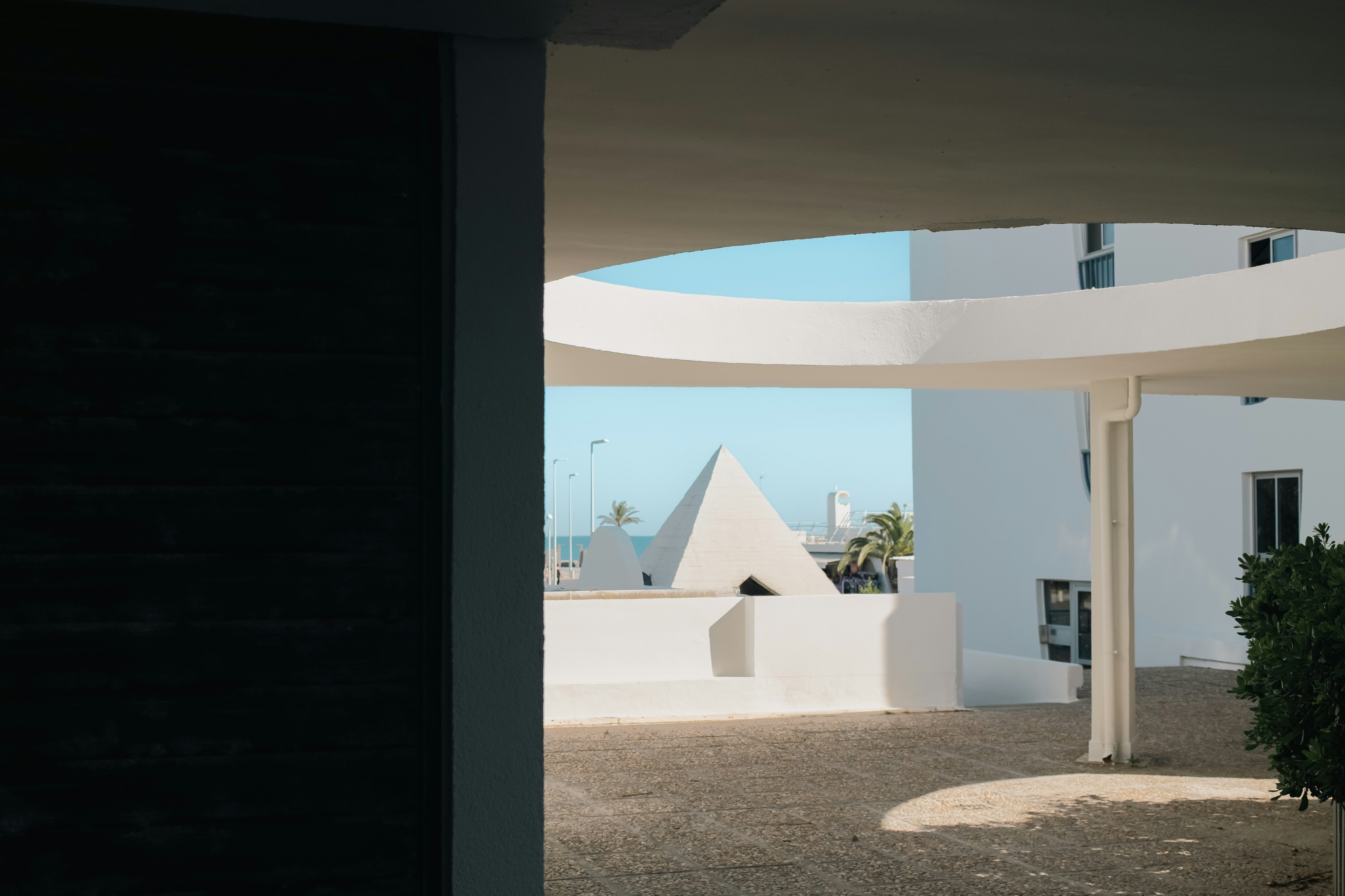 Deserted Archways: White Geometrics Against a Coastal Sky