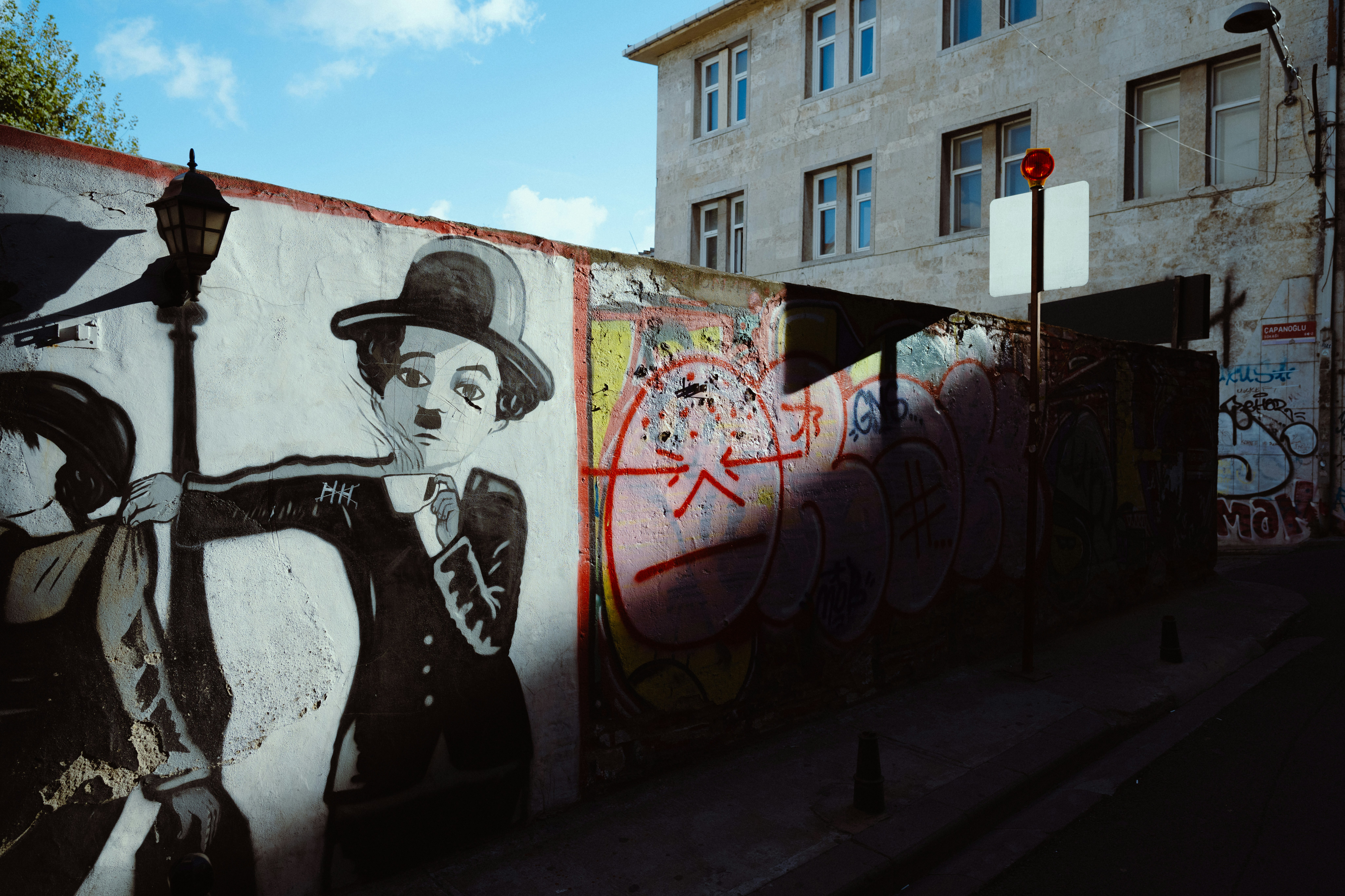 Graffiti Portraits Along a Street Wall