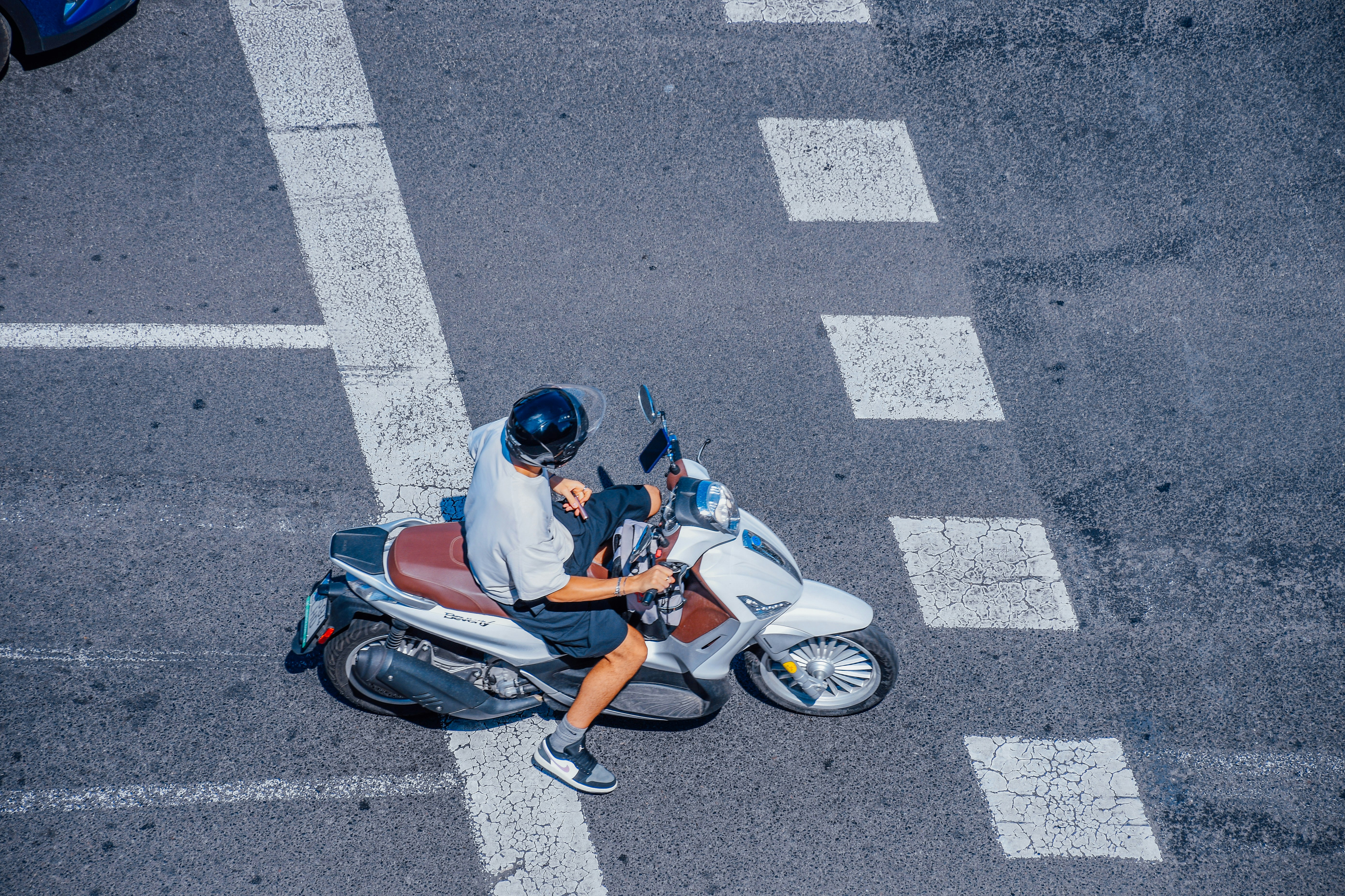 A Rider in Transit: Aerial View of a Scooterist in the City Grid