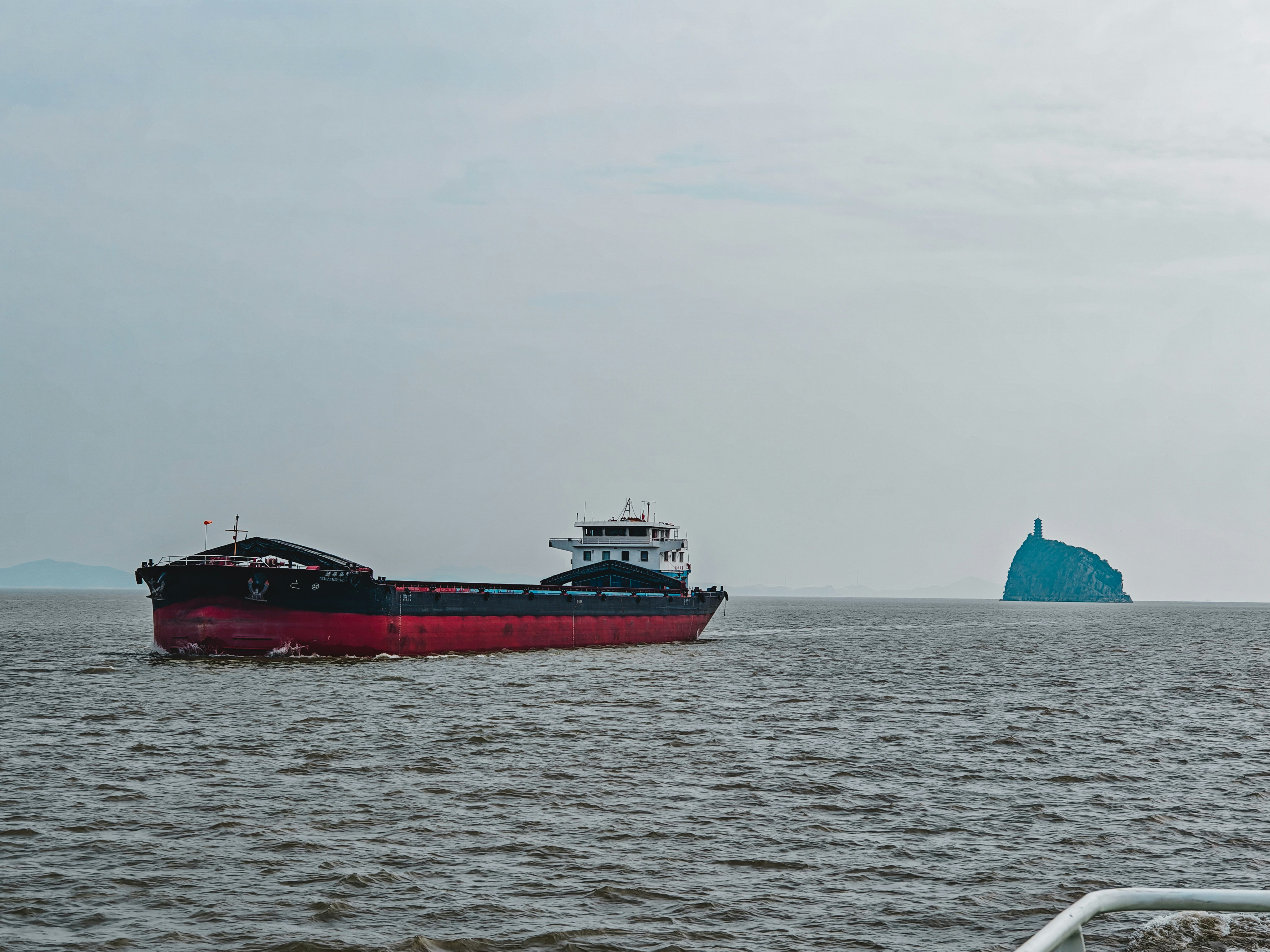 Red Hull, Blue Horizon: A Vessel Marks the Quiet Sea