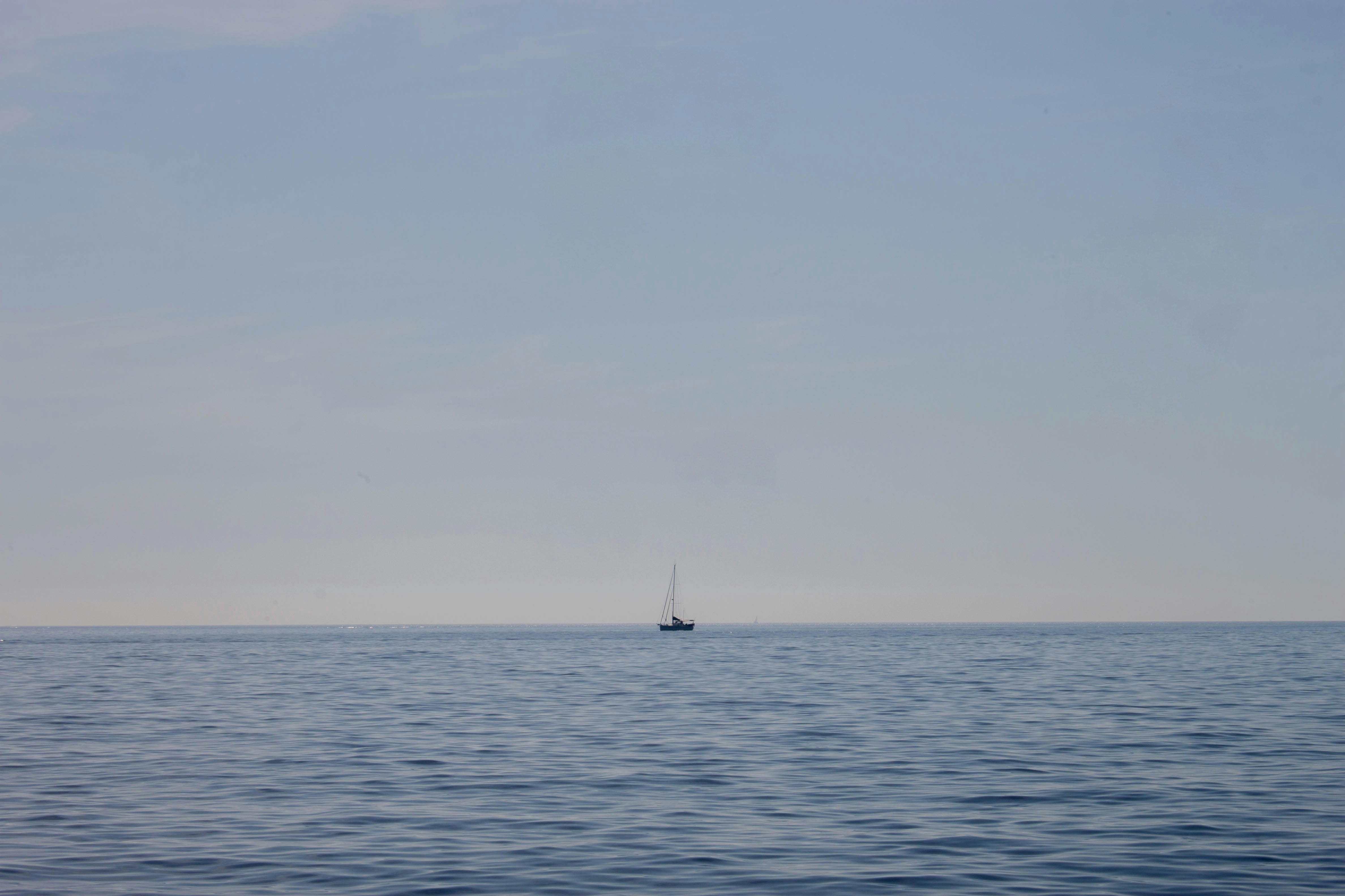 A lone sailboat on a tranquil horizon