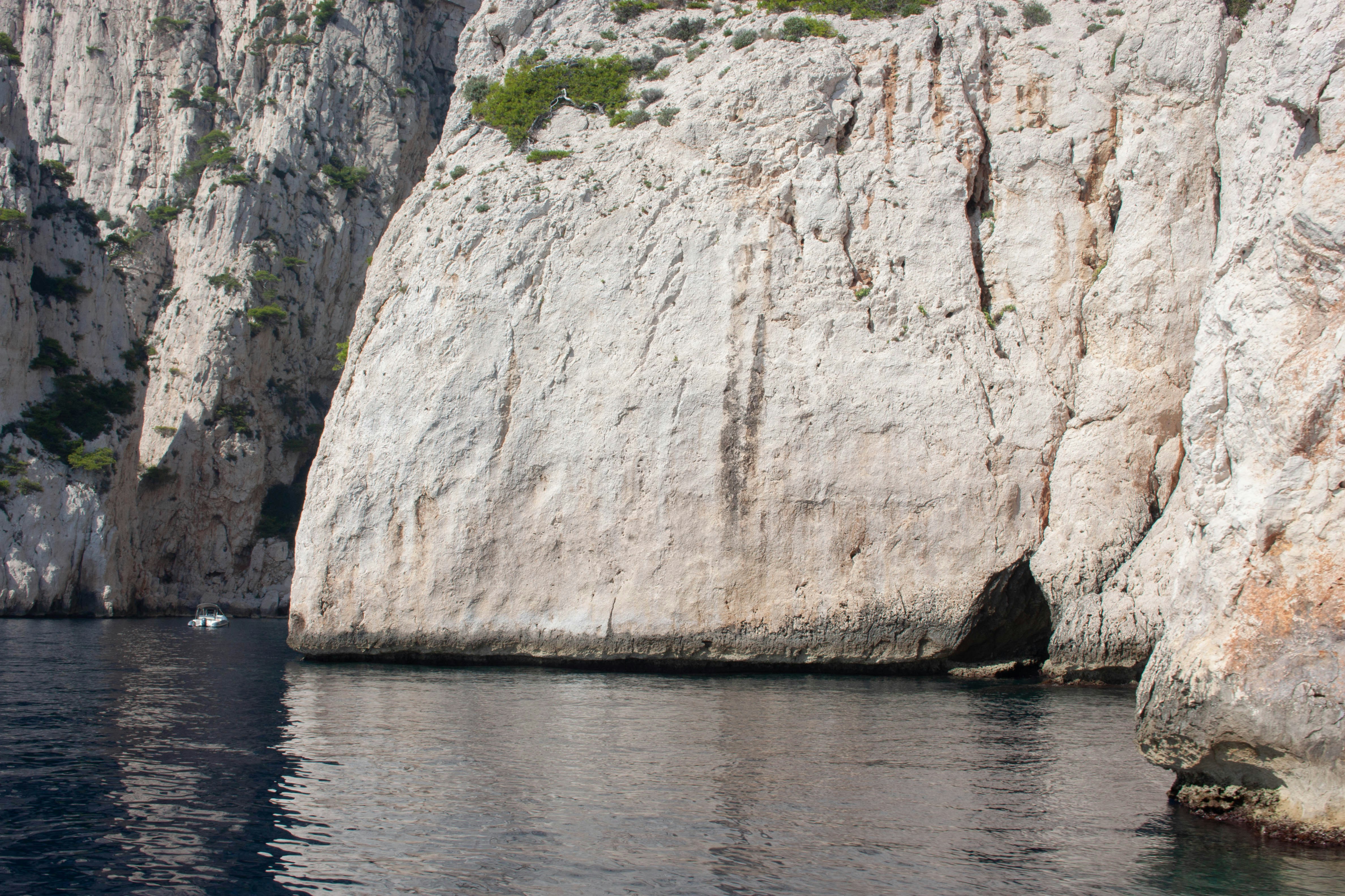 Cliffside Grotto: Sunlit Limestone Overlooking Calm Sea