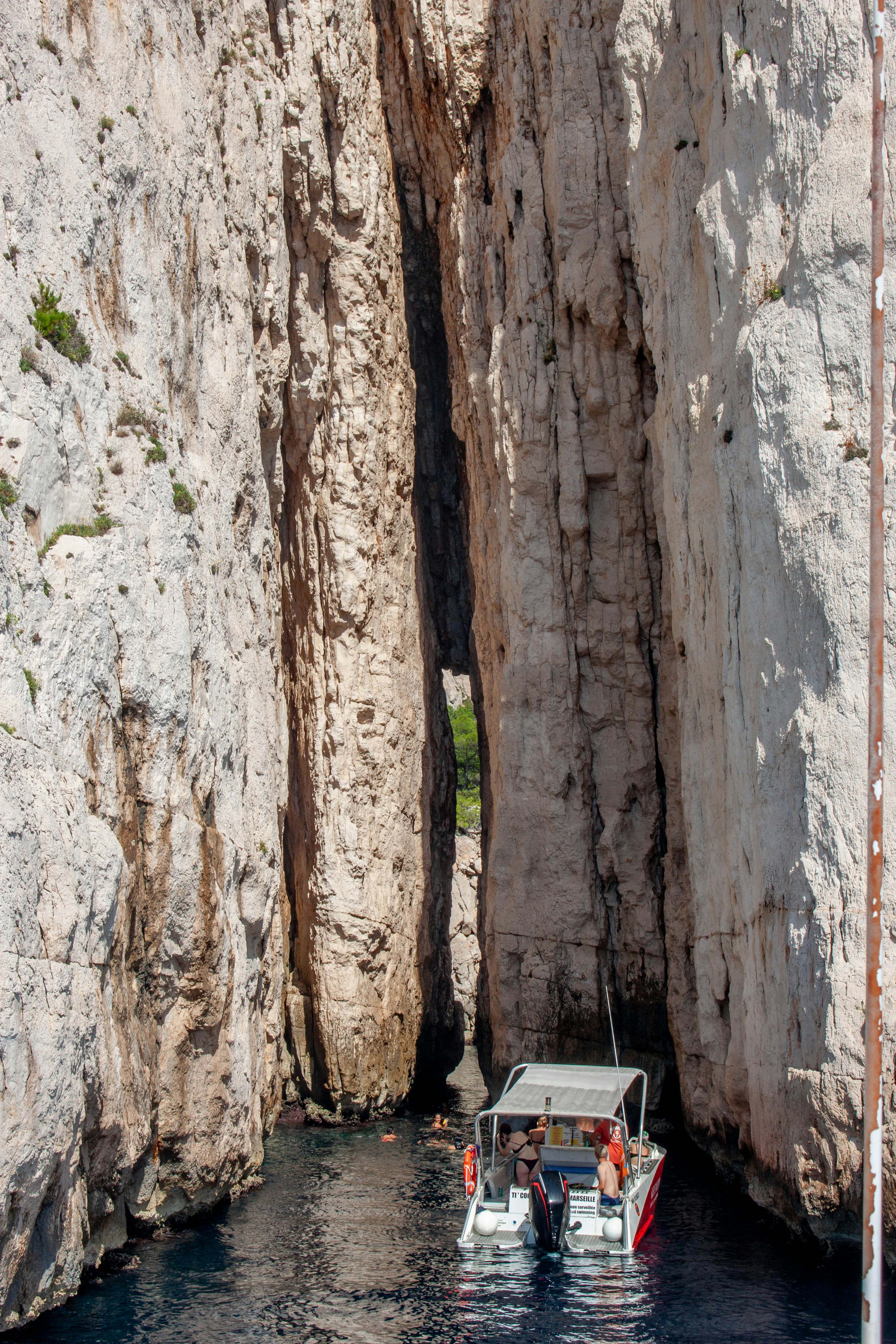 Through the Narrow Gap: A Bright Boat in a Sea of Vertical Cliffs