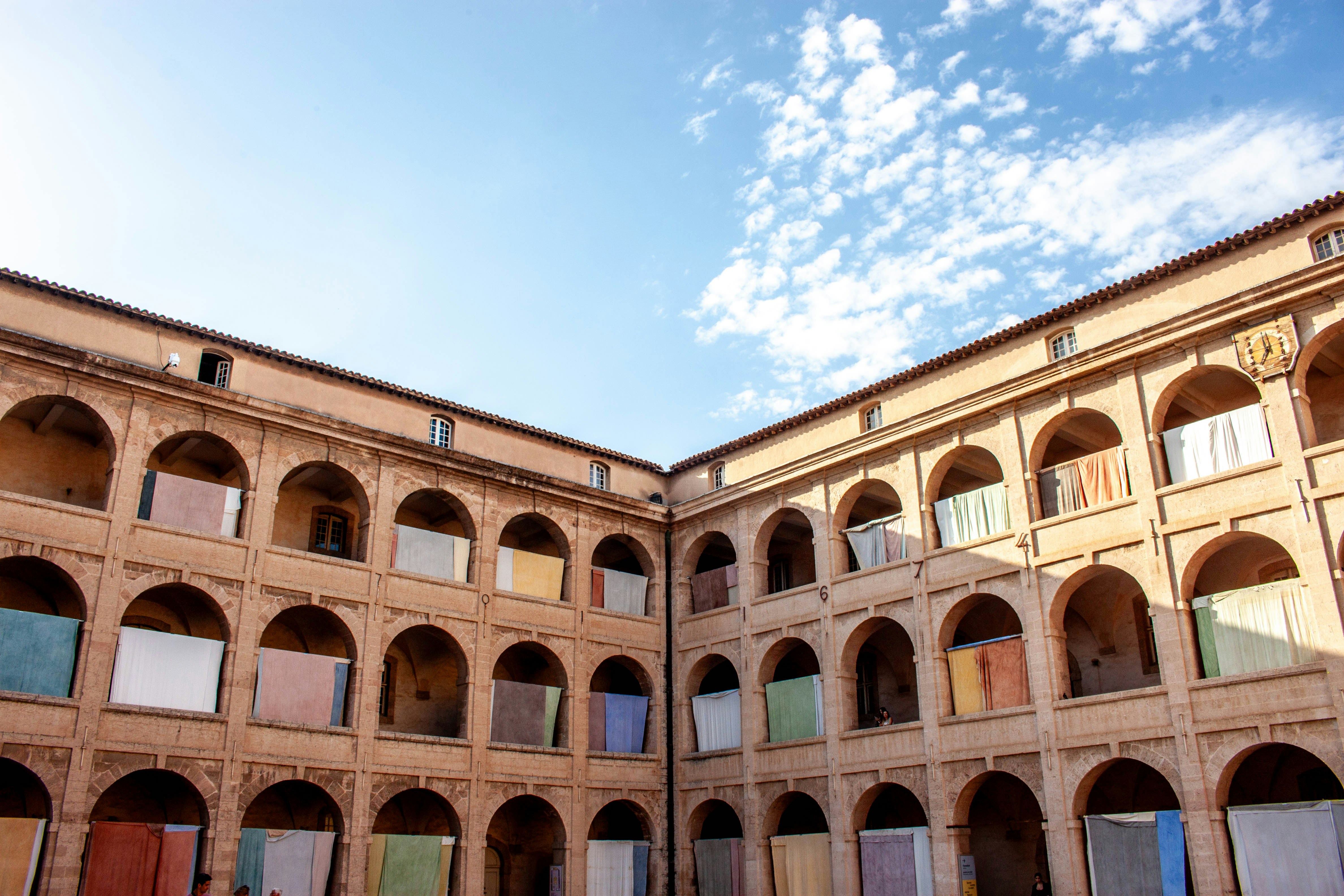 Symmetrical Courtyard Echoes: Arches and Sky