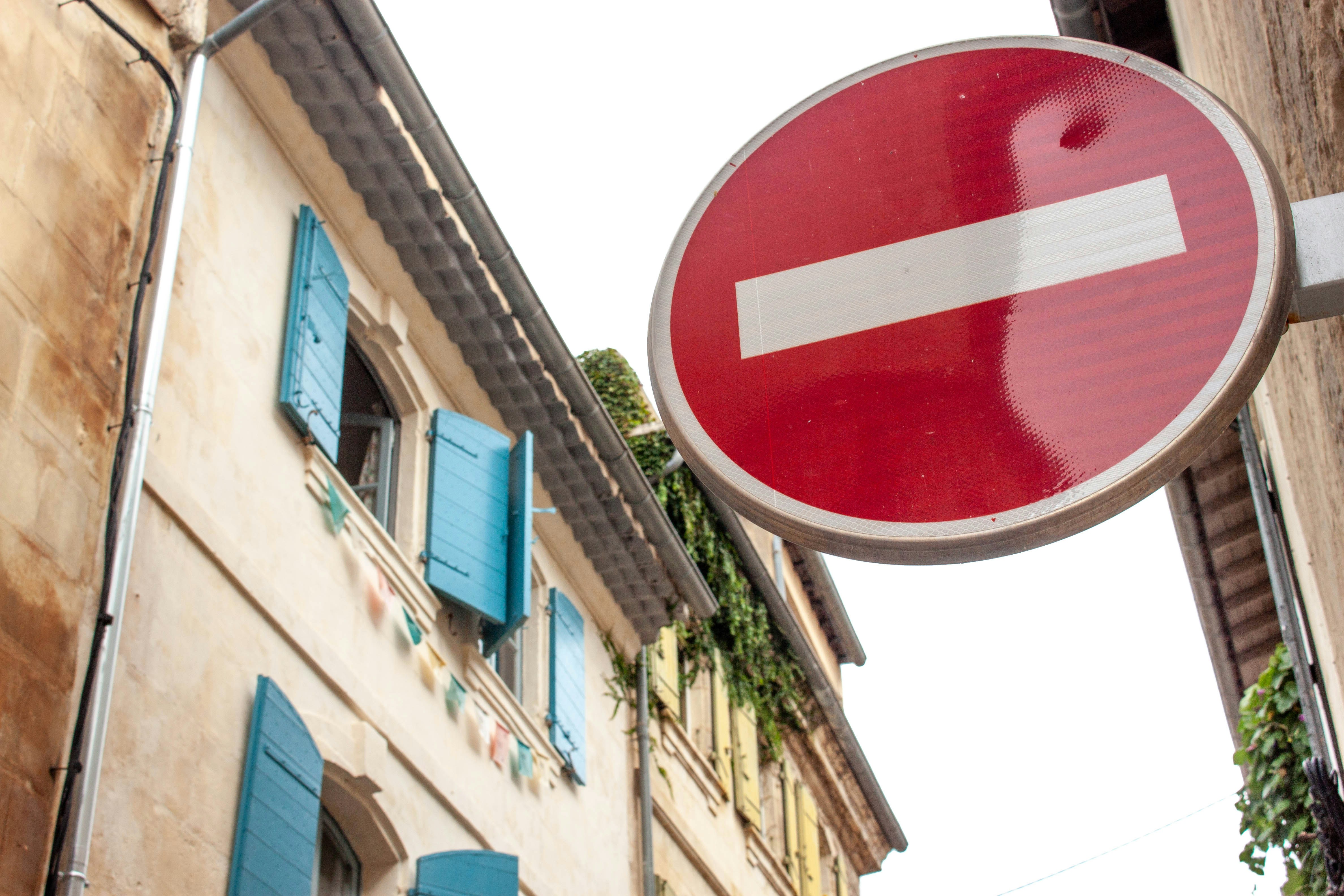 No Entry, Sunlit Courtyard: A Street Sign Dominates a European Facade
