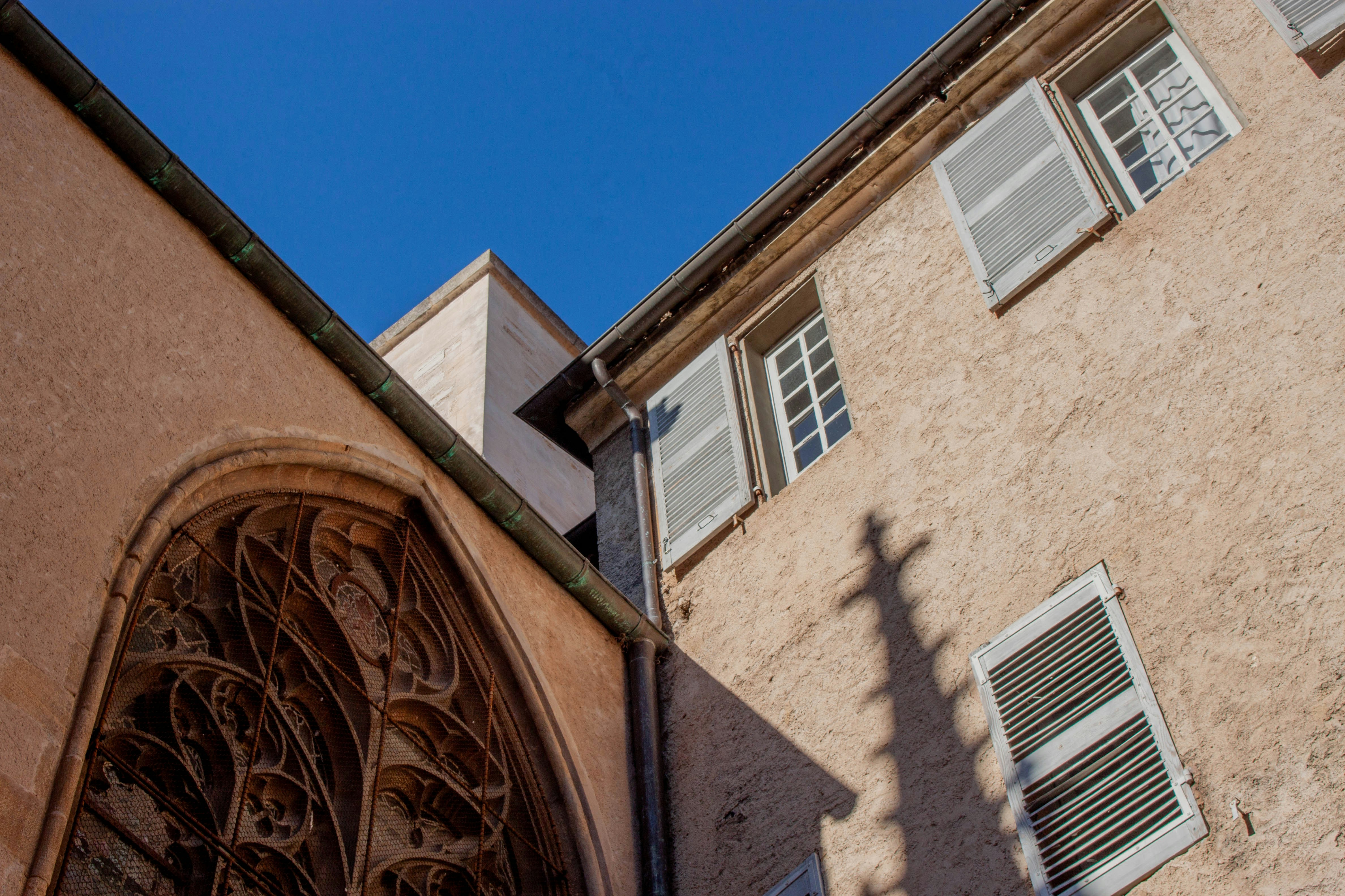 Sunlit Facade and Gothic Arch: An Upward Glimpse into a historic corner