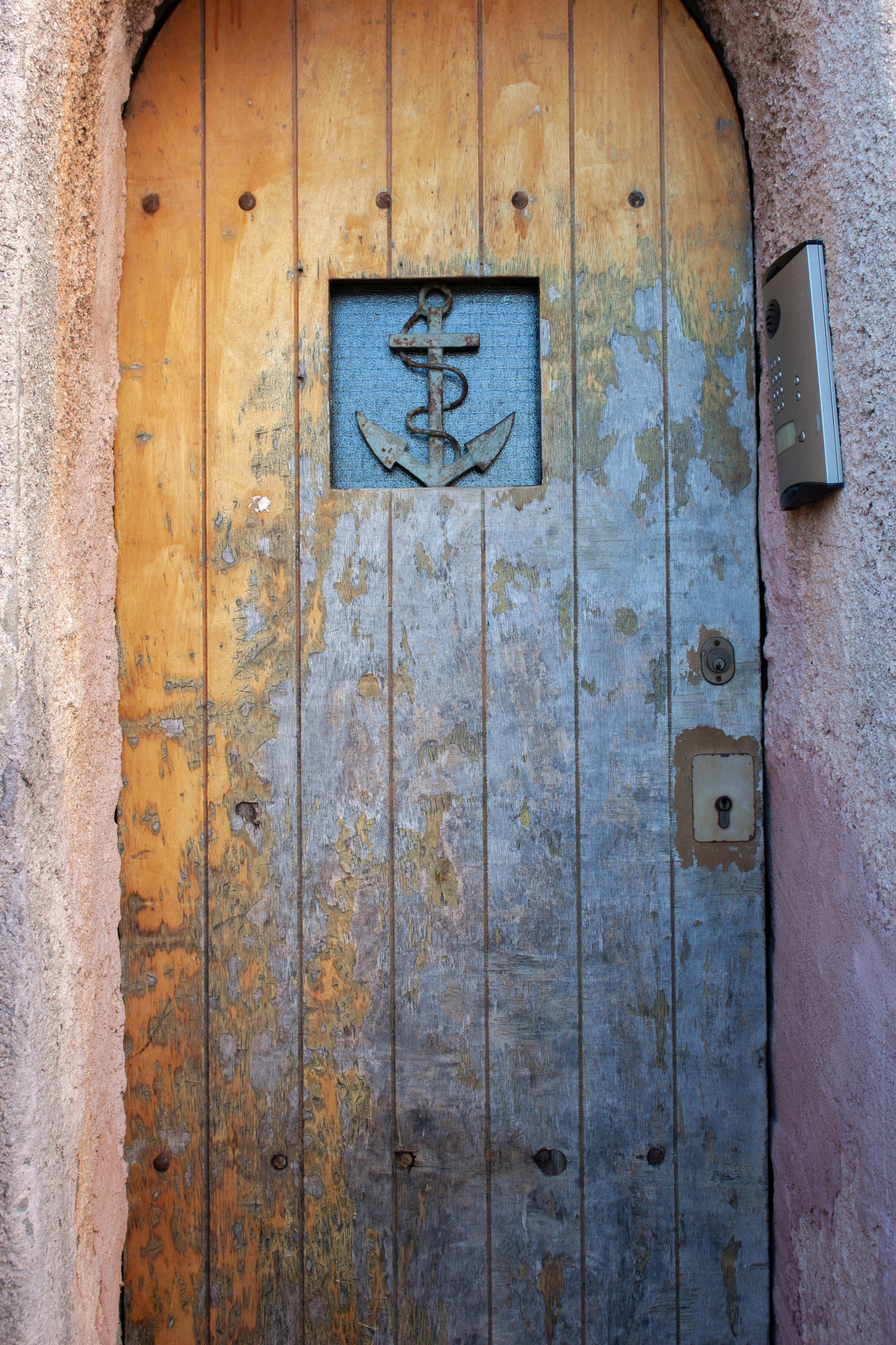 Anchored Door: Weathered Ship Symbol Framed by Rustic Planks