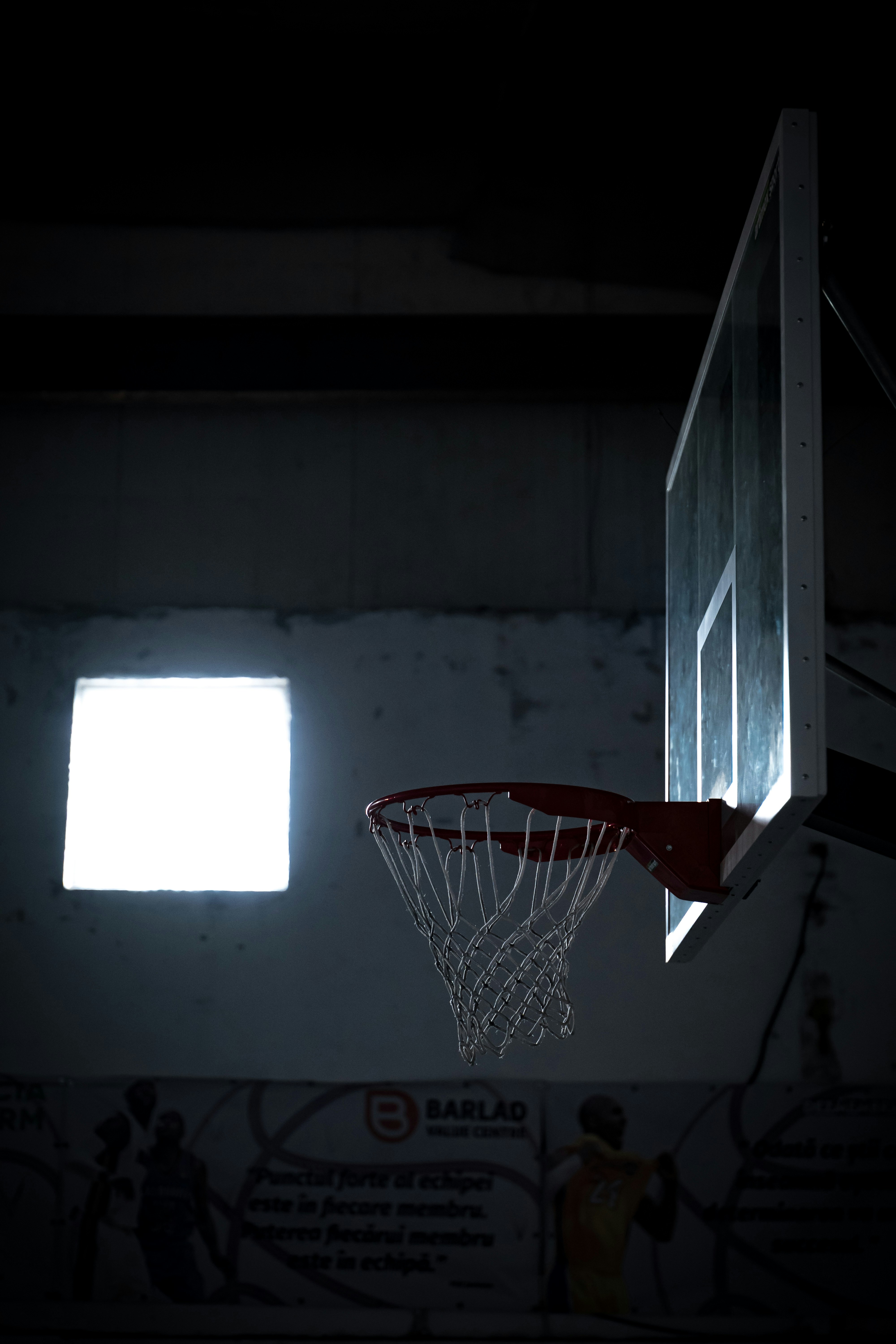 Basketball Hoop in a Dim Gym: Silent Spotlight on the Net