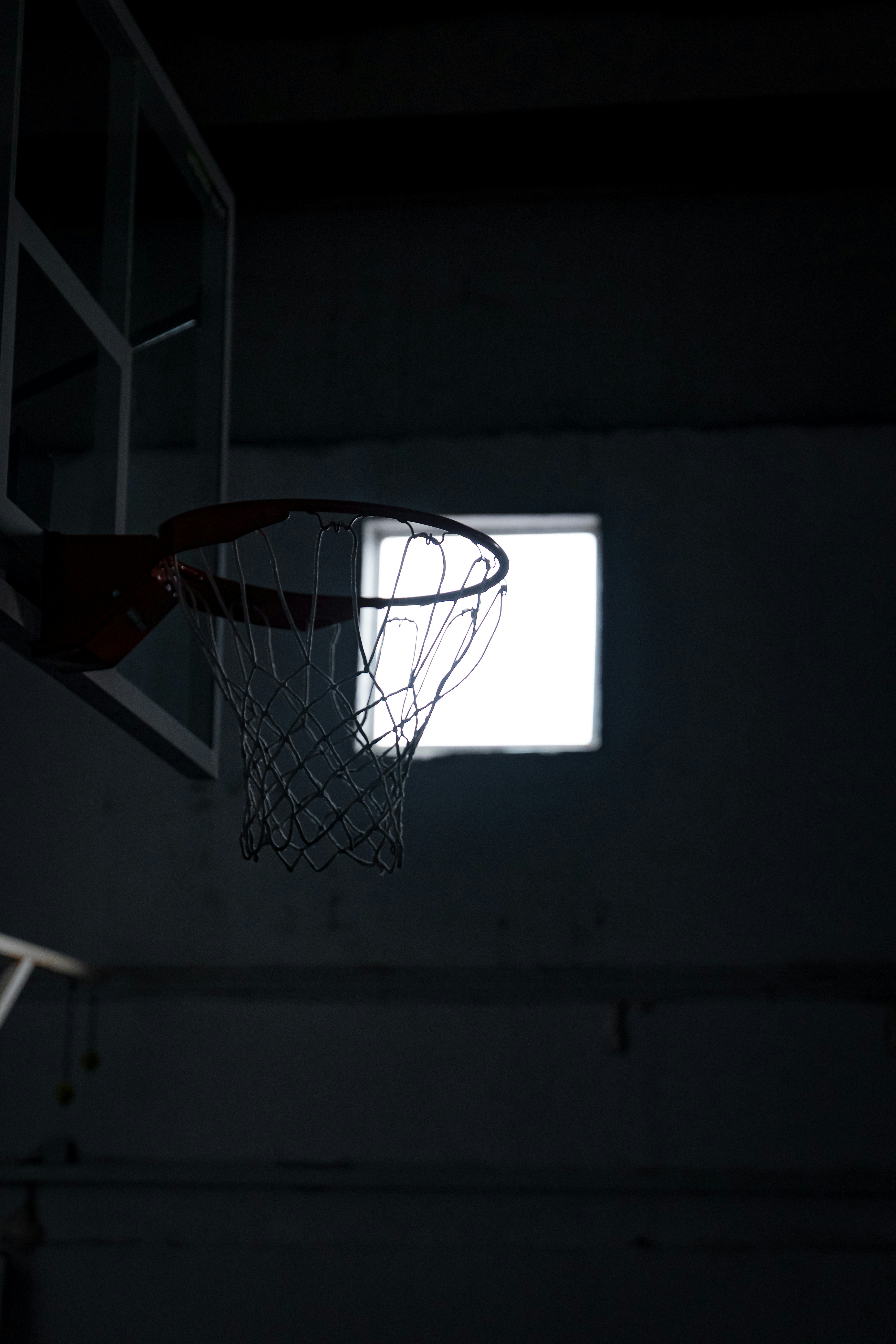 Dim Gymnasium Hoop Quietly Reaches for Light