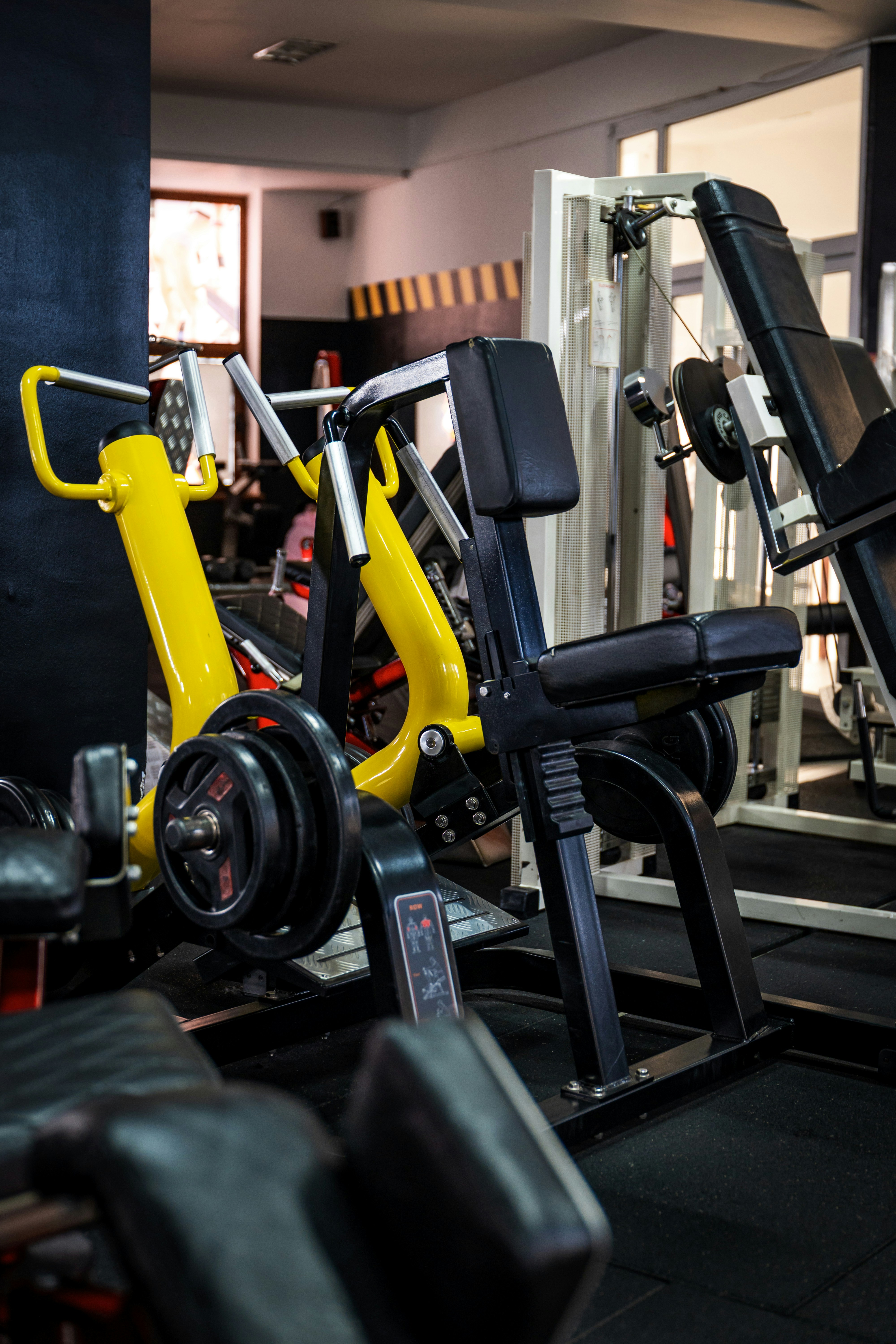 Yellow Strength Machine in Gym — Focus on the Central Leg Extension Arm