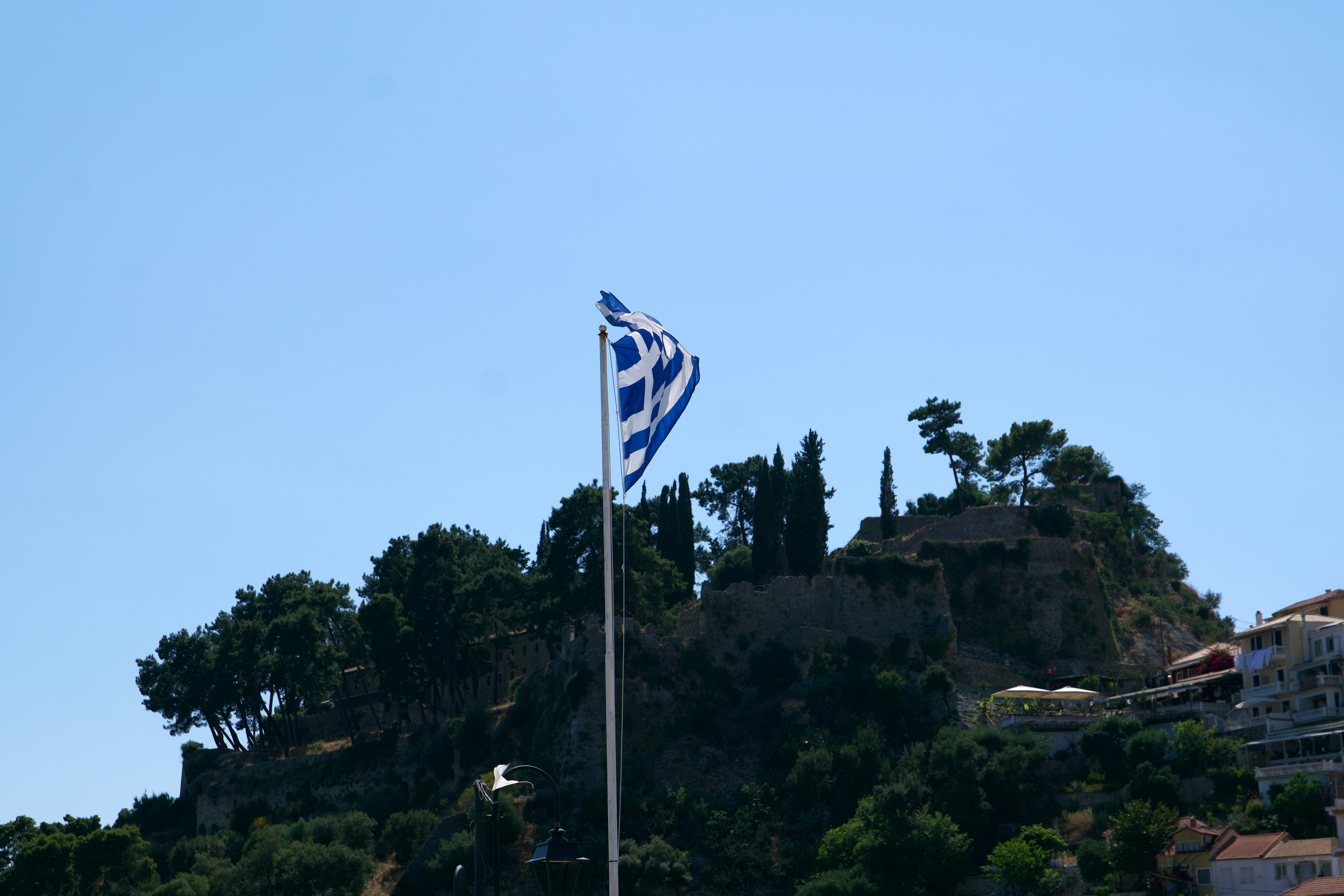 Flag over the hillside: coastal Greece in clear sky