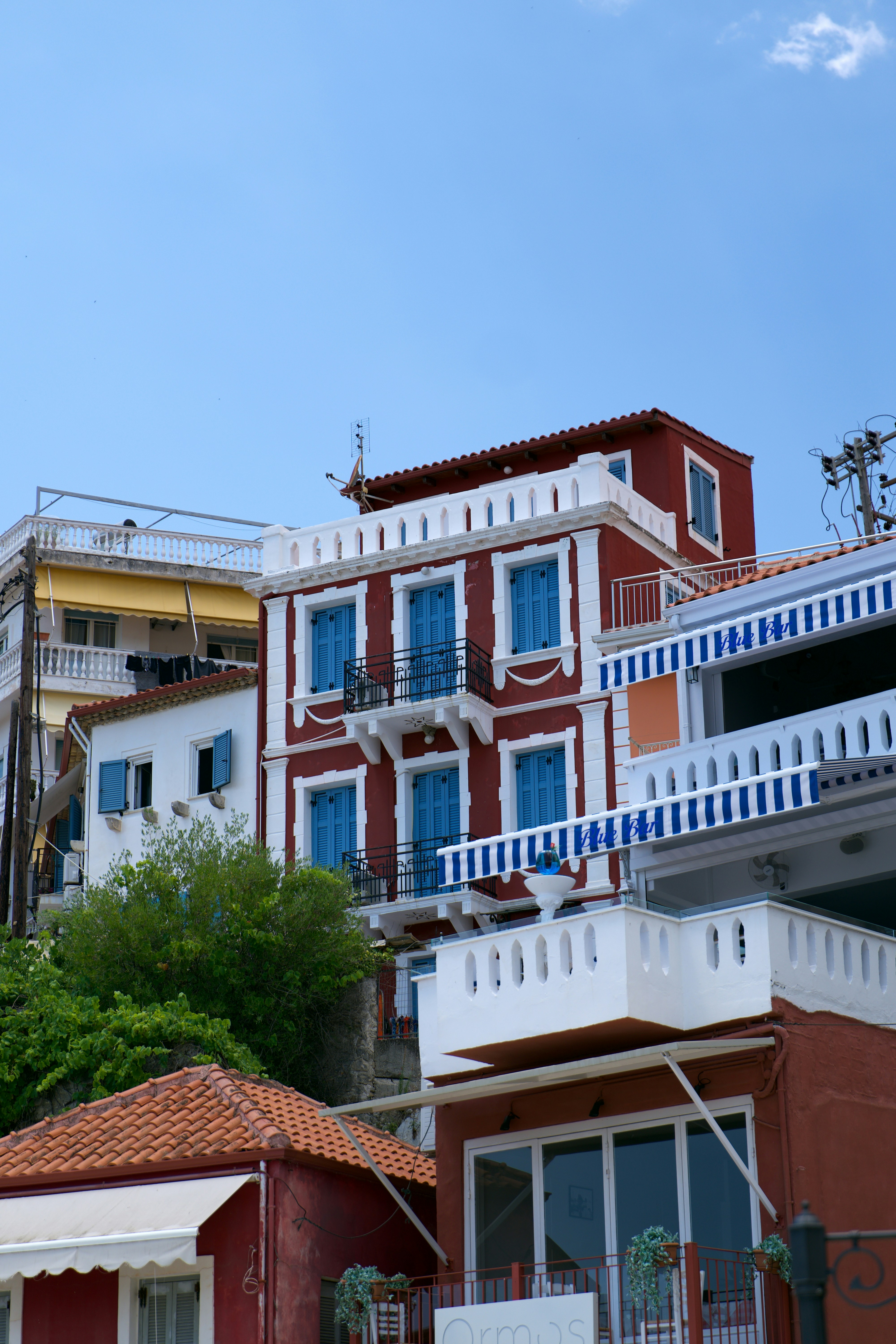 Colorful Mediterranean Facade with Blue Shutters and Terraced Balconies