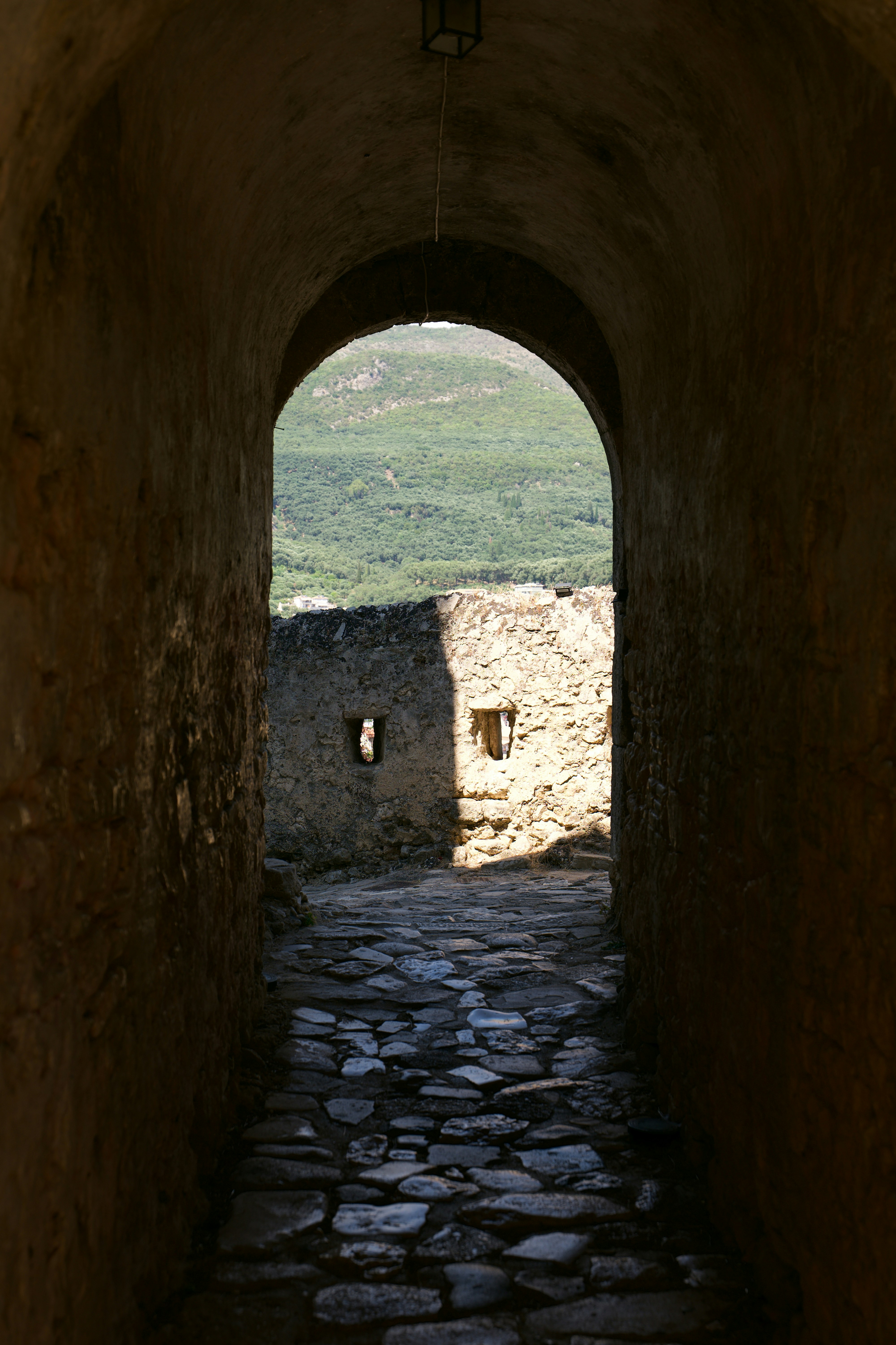 Archway to the Valley: Light Creeps Through a Stone Corridor