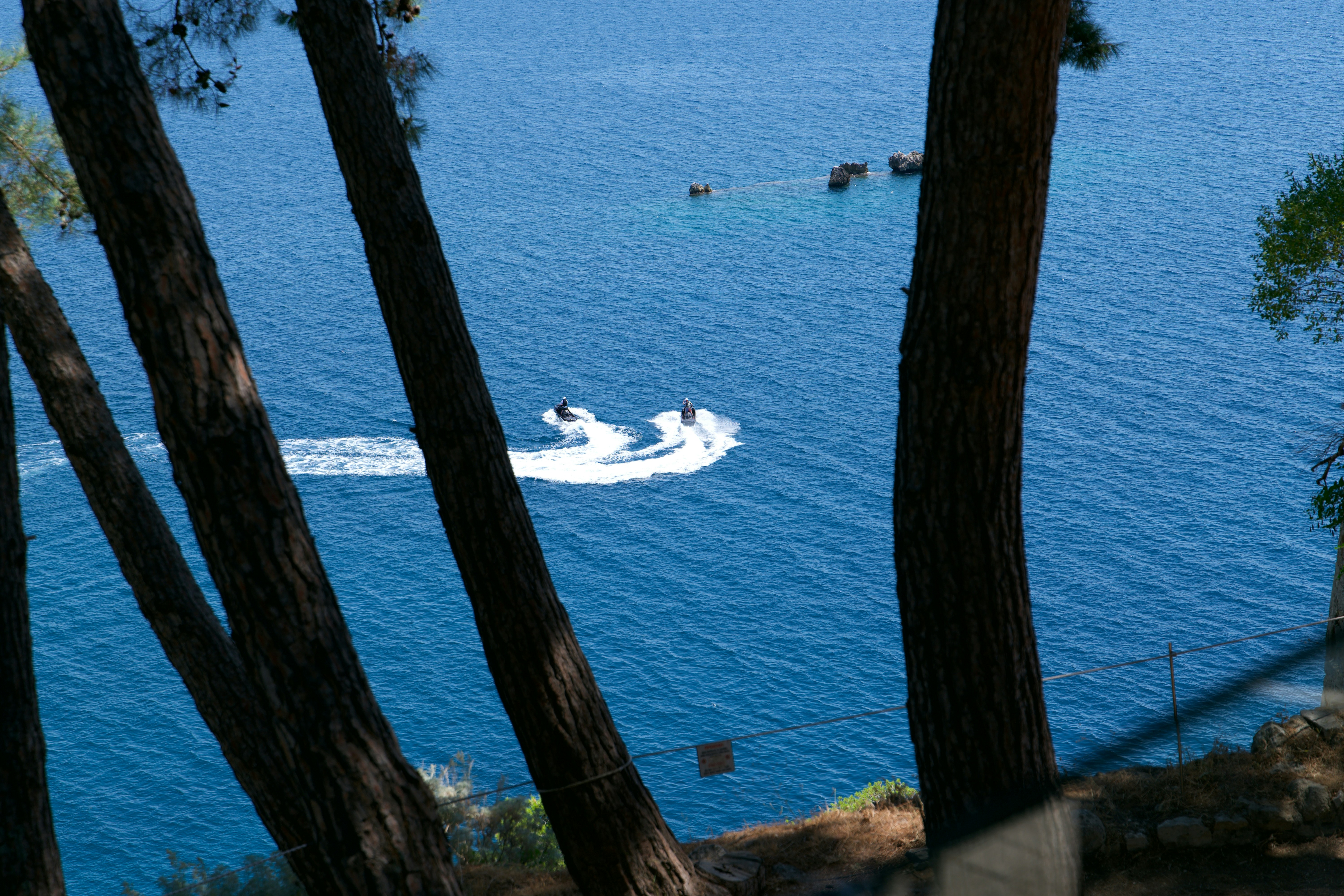 Skimming wake: two jet skis carving a white arc on blue Mediterranean