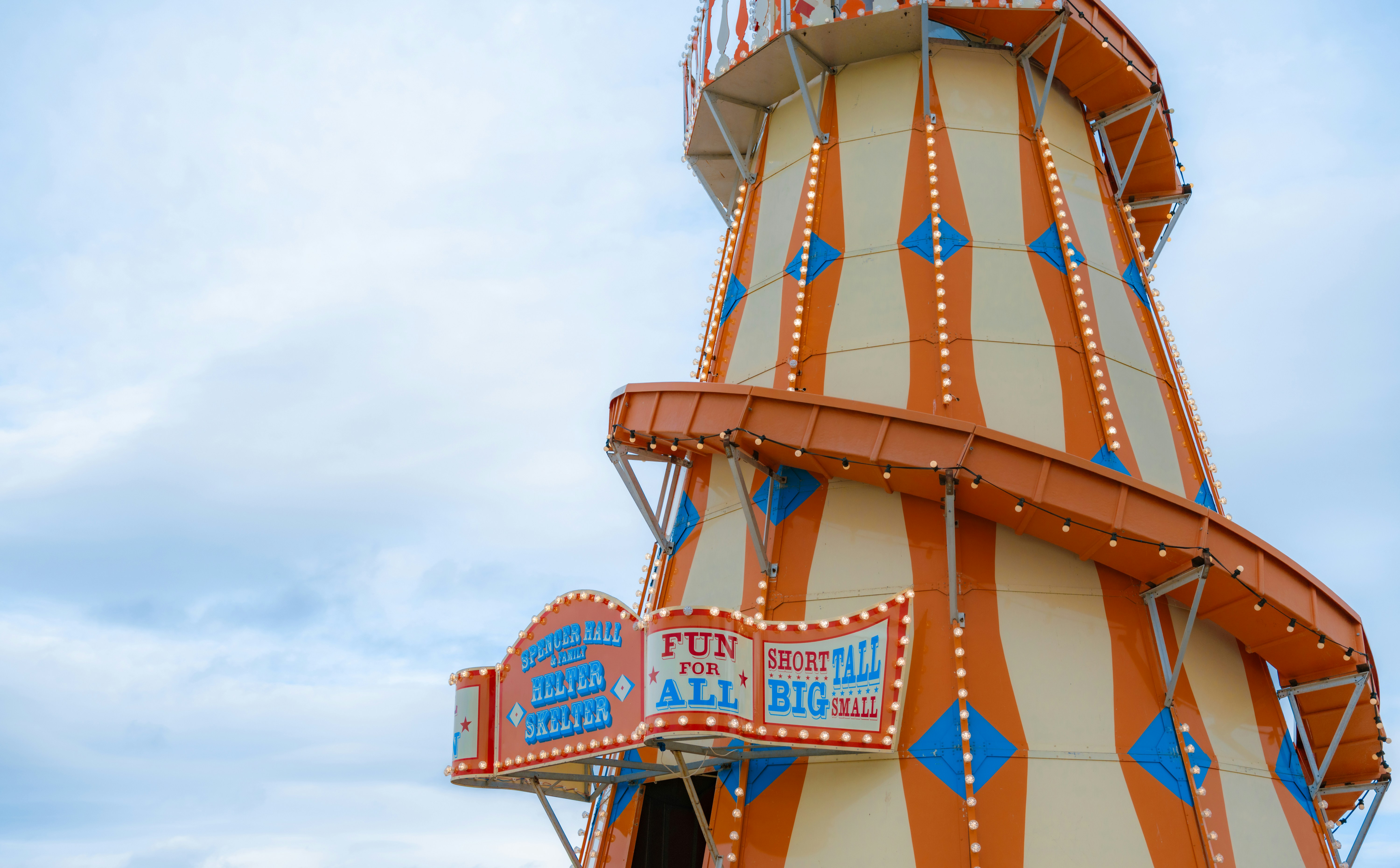 Whimsical tower of stripes and signs at sunset fairground
