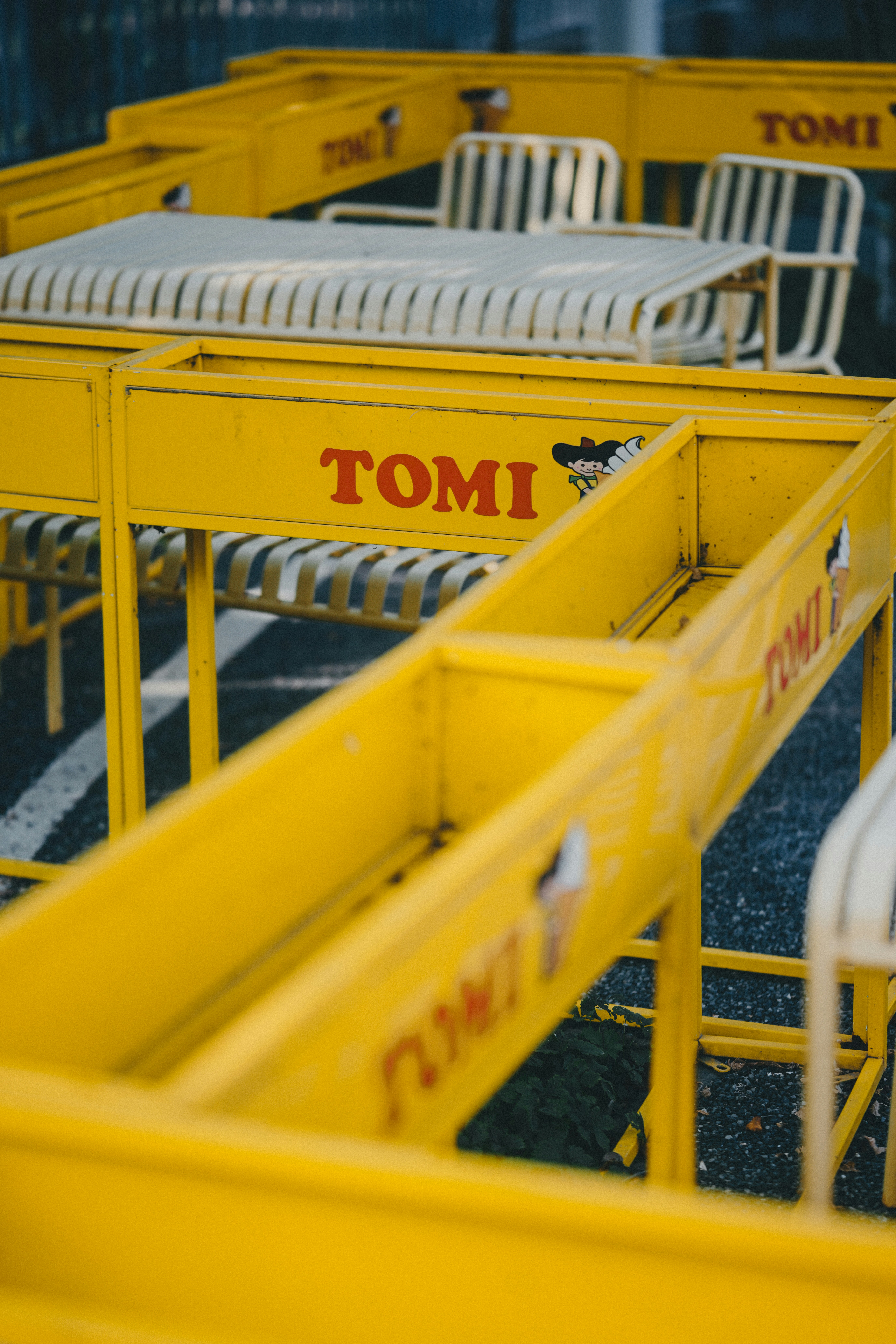 Brightwarning: A row of vibrant yellow stadium chairs framing a scene of repetitive geometry