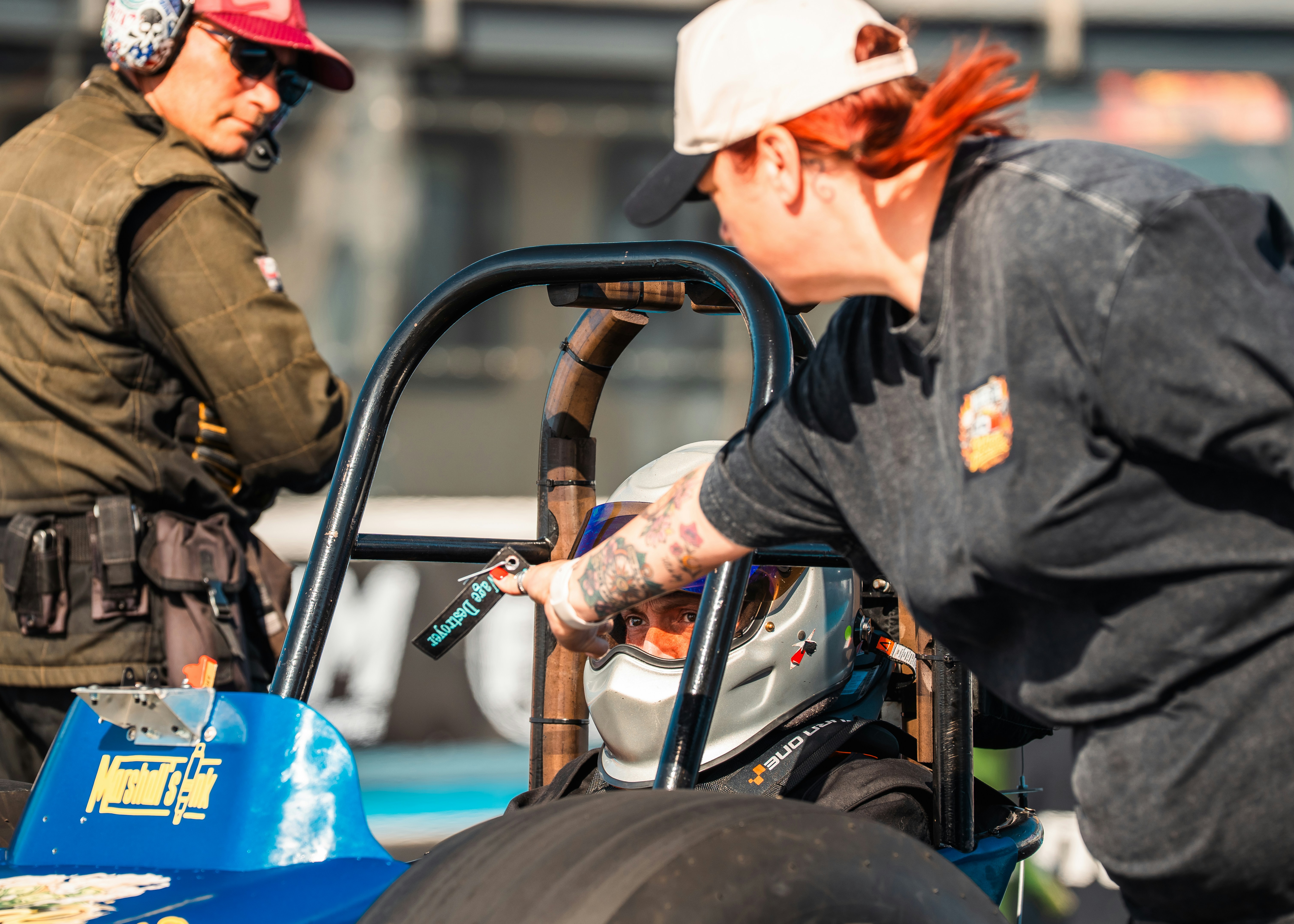 Helmeted Driver in Pit Stop: The Hands-On Moment