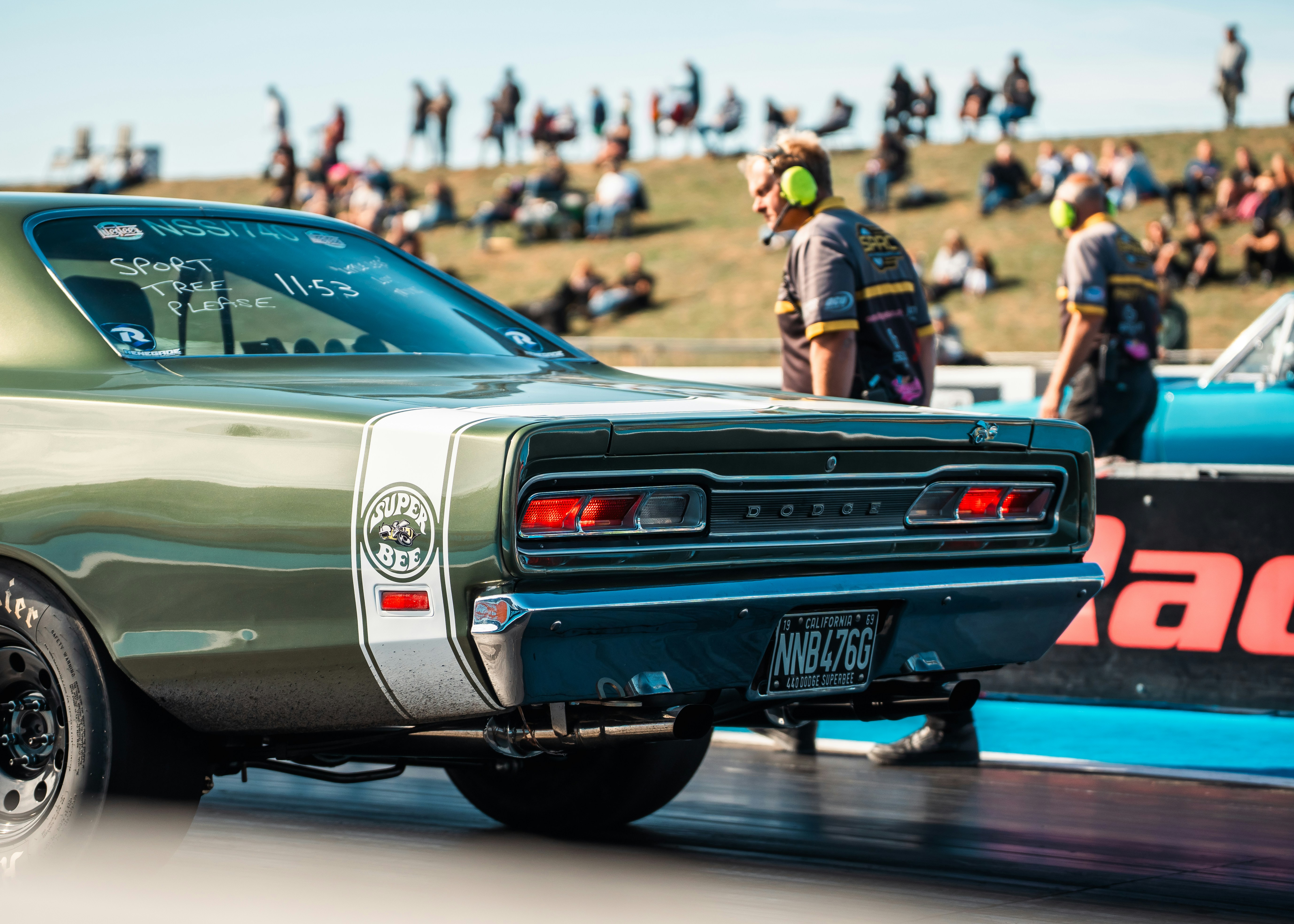 Green classic on the drag strip: a vintage Dodge roars under the crowd