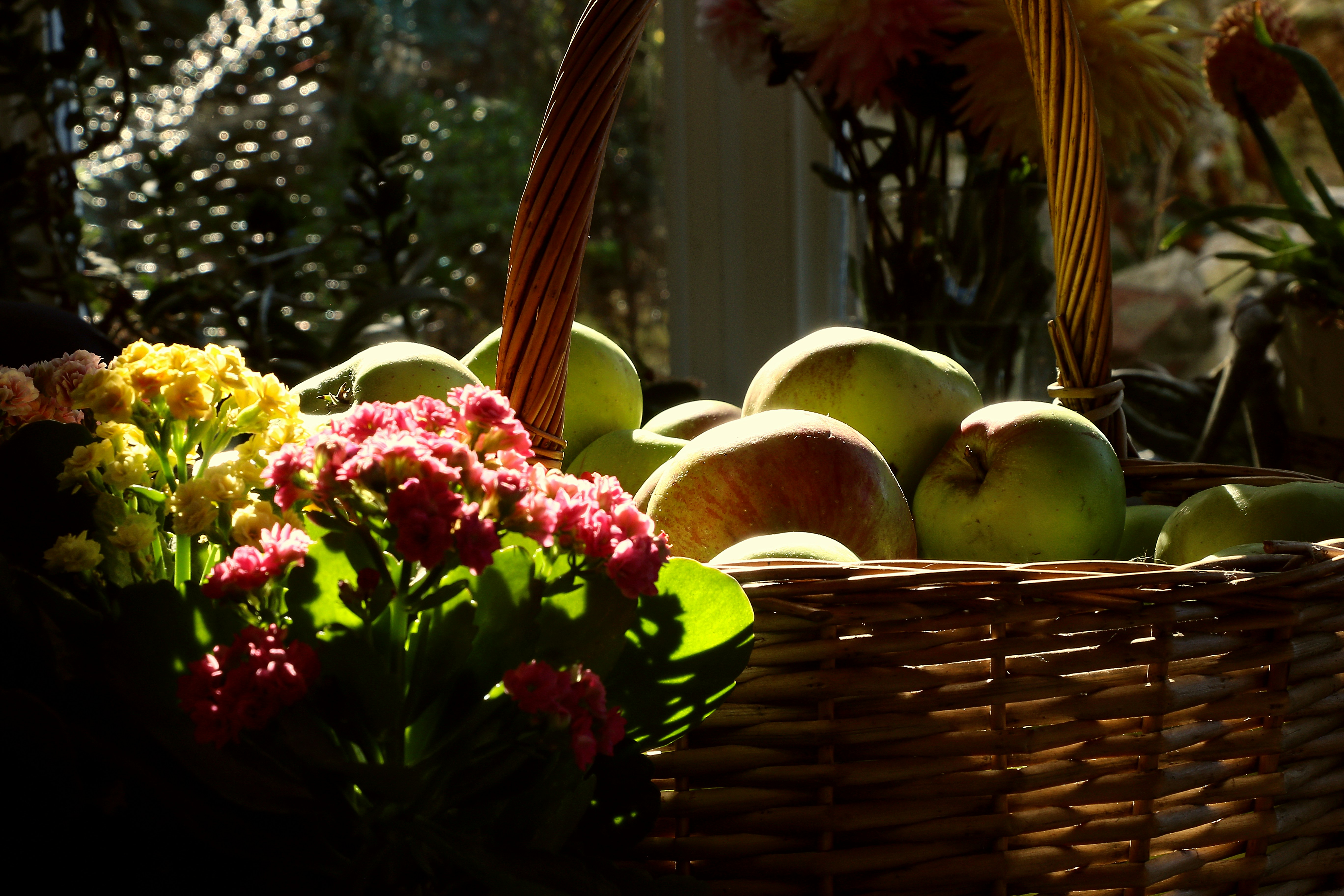Basket of peaches and vibrant bouquet at late afternoon market light