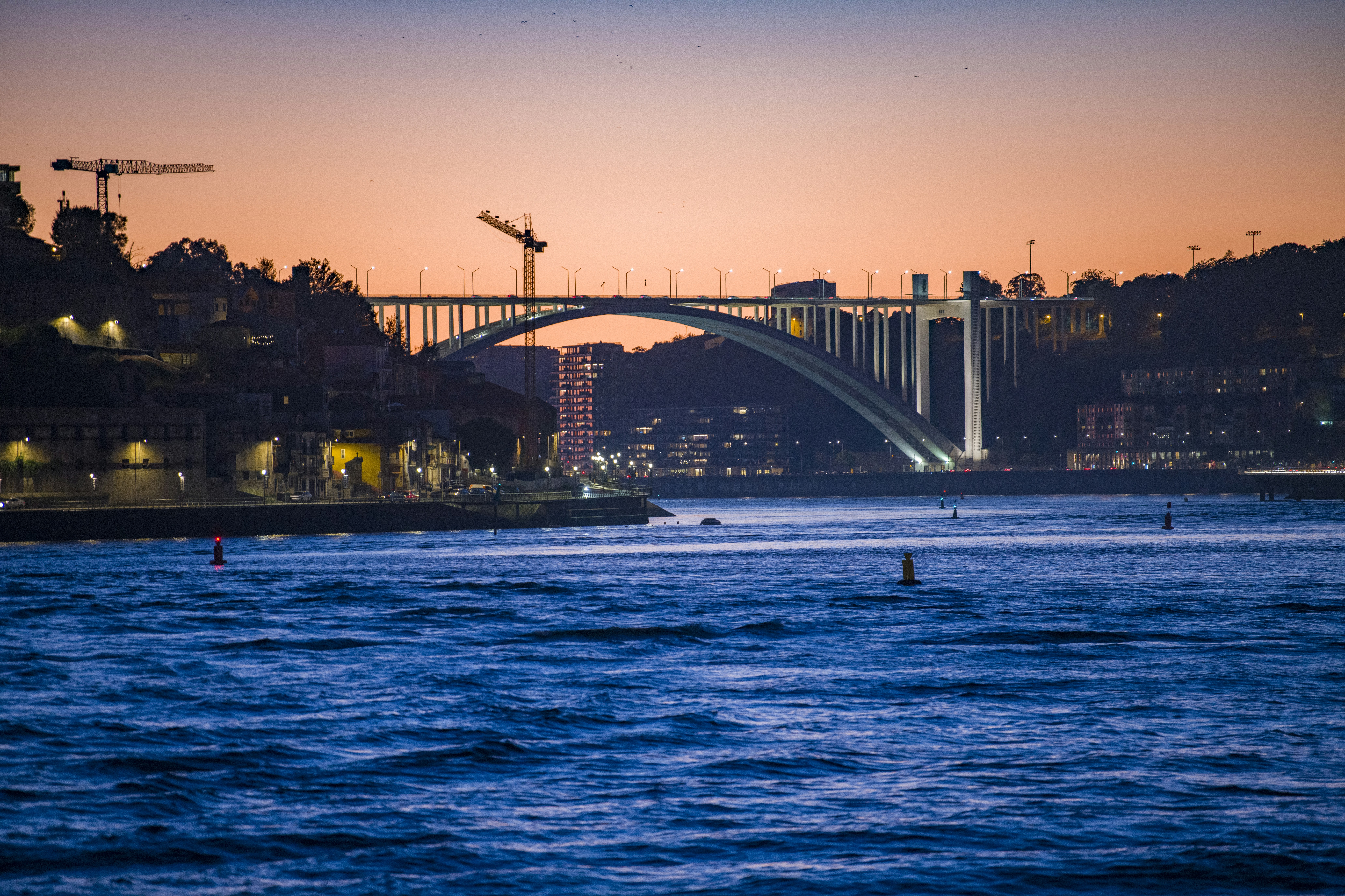 Distant Arc: Sunset Over the River with City Bridge