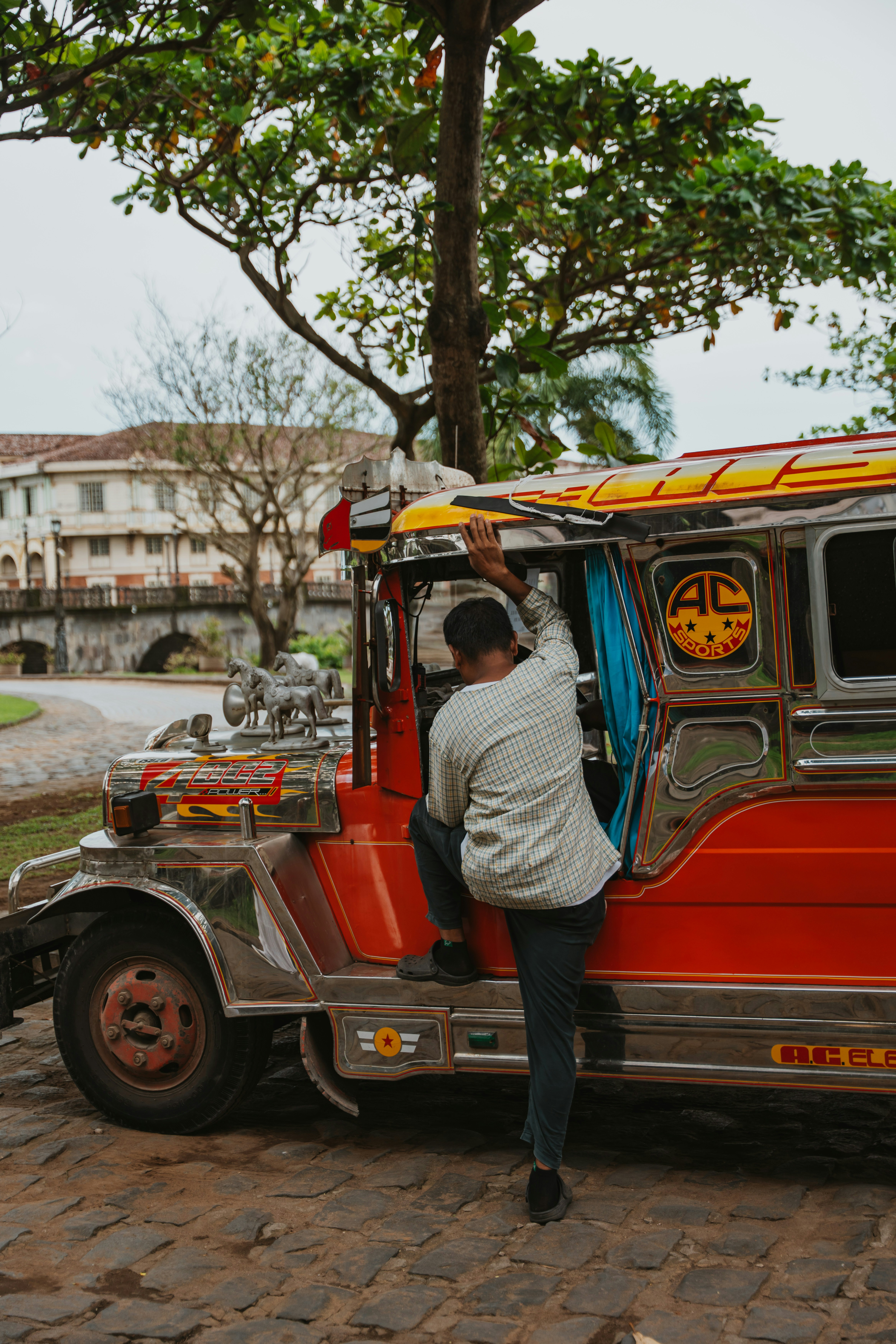Burden of the Ride: A Climber Clings to a Colorful Tuk Tuk
