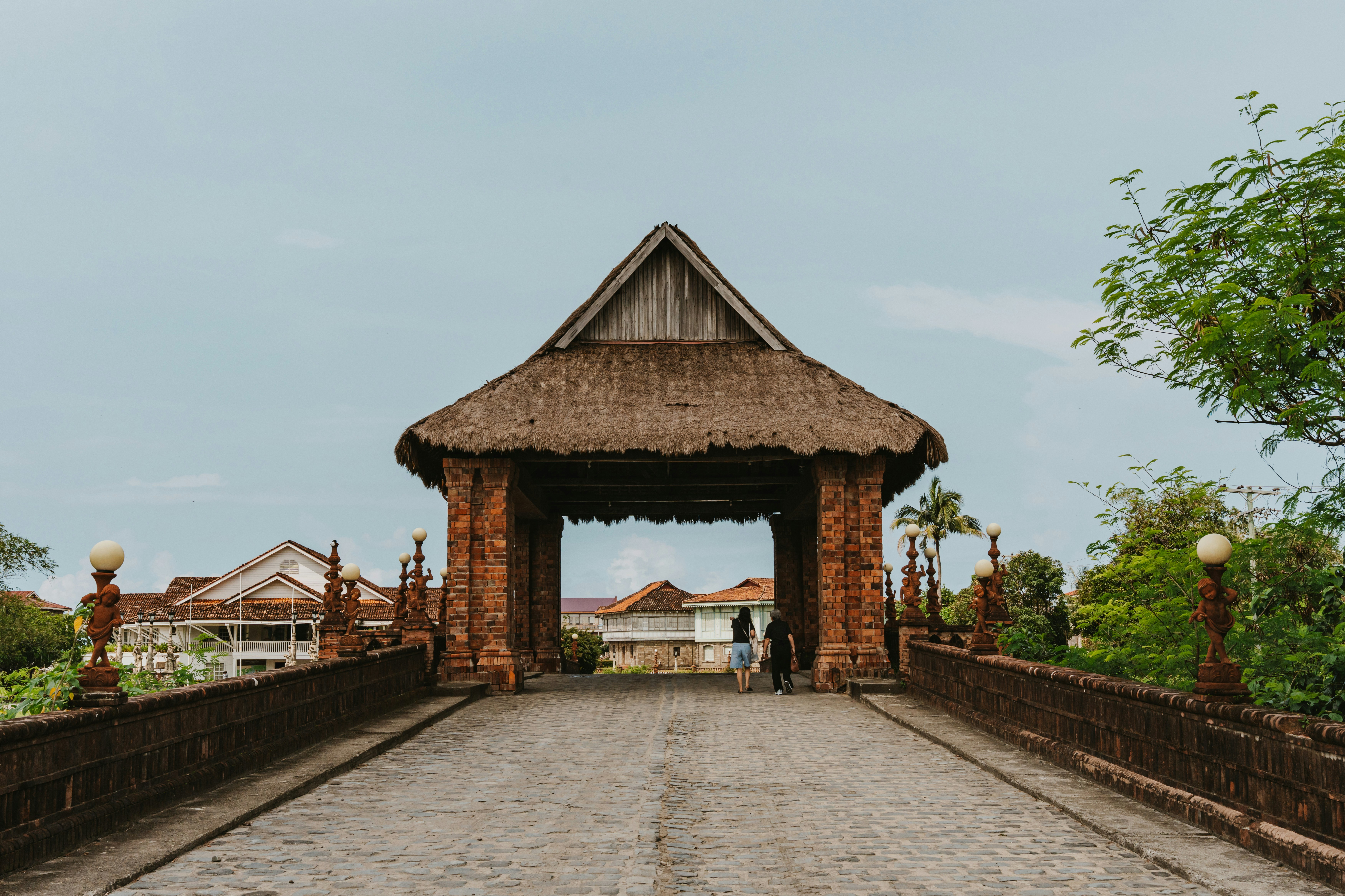 Gateway to the Horizon: A Thatched Arch on a Stone Bridge