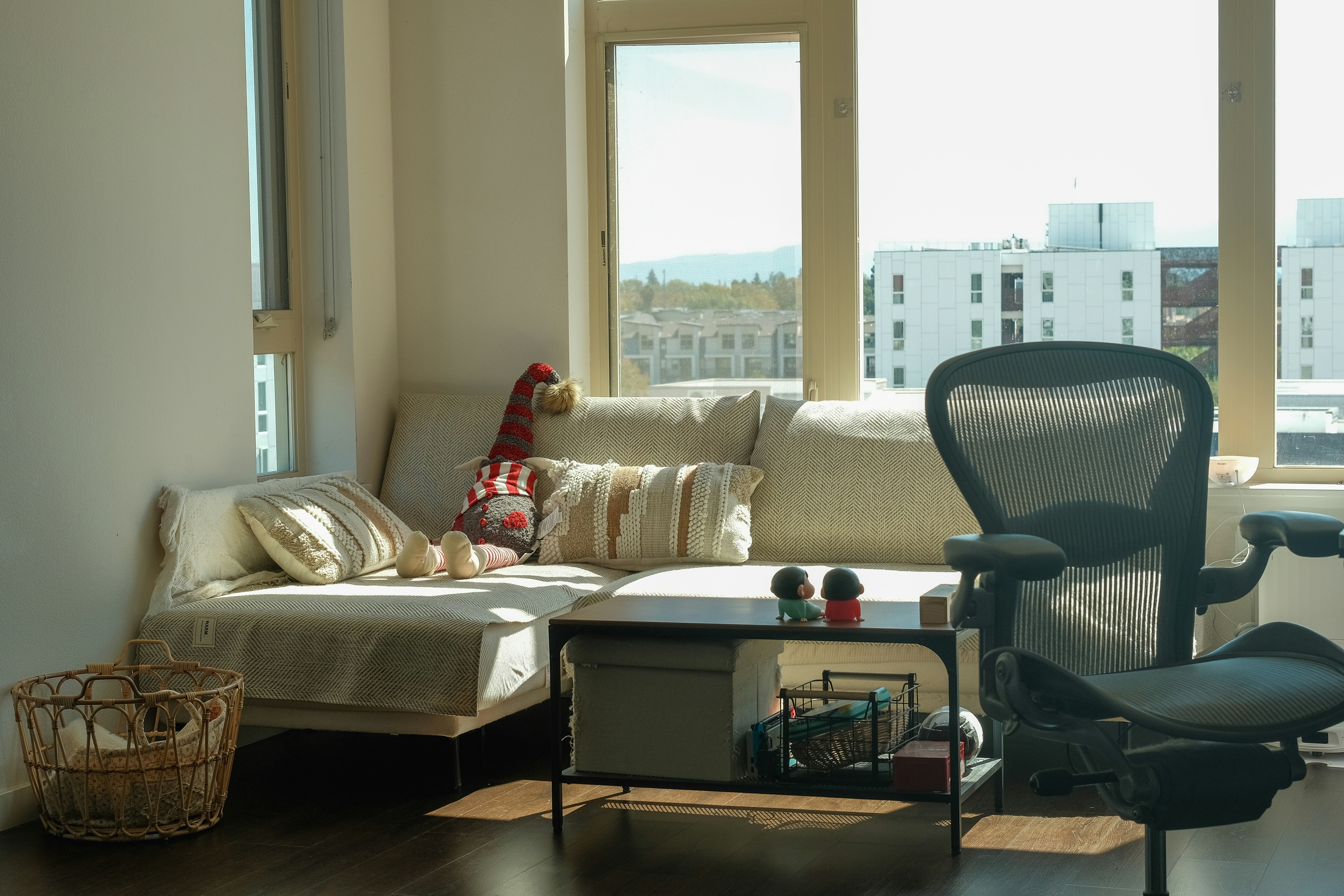 Cozy living room corner with a plush sofa and ergonomic chair bathed in morning light