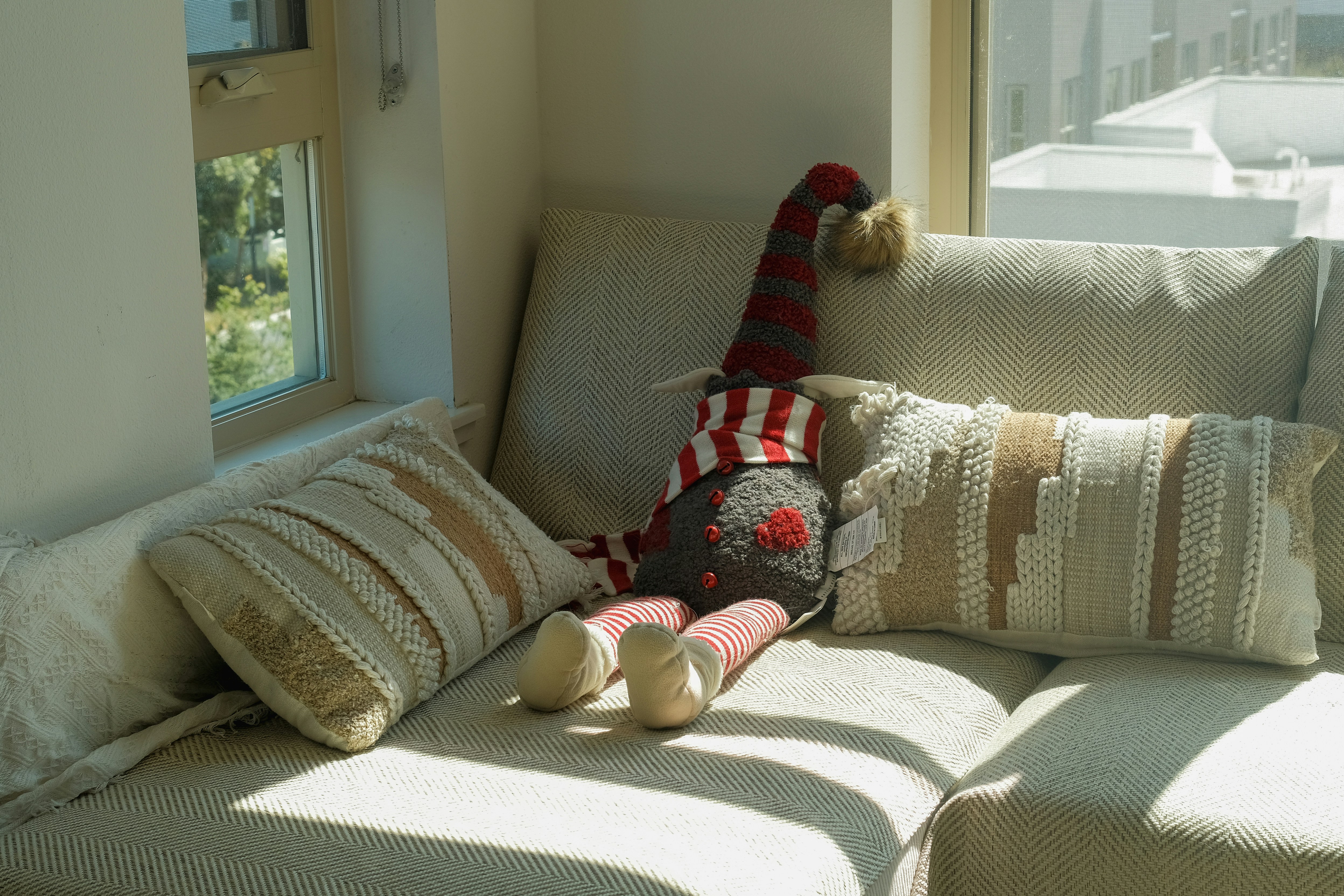 Sewn-away in Sunlight: A Plush Nordic Figure Resting on a Cozy Window Seat