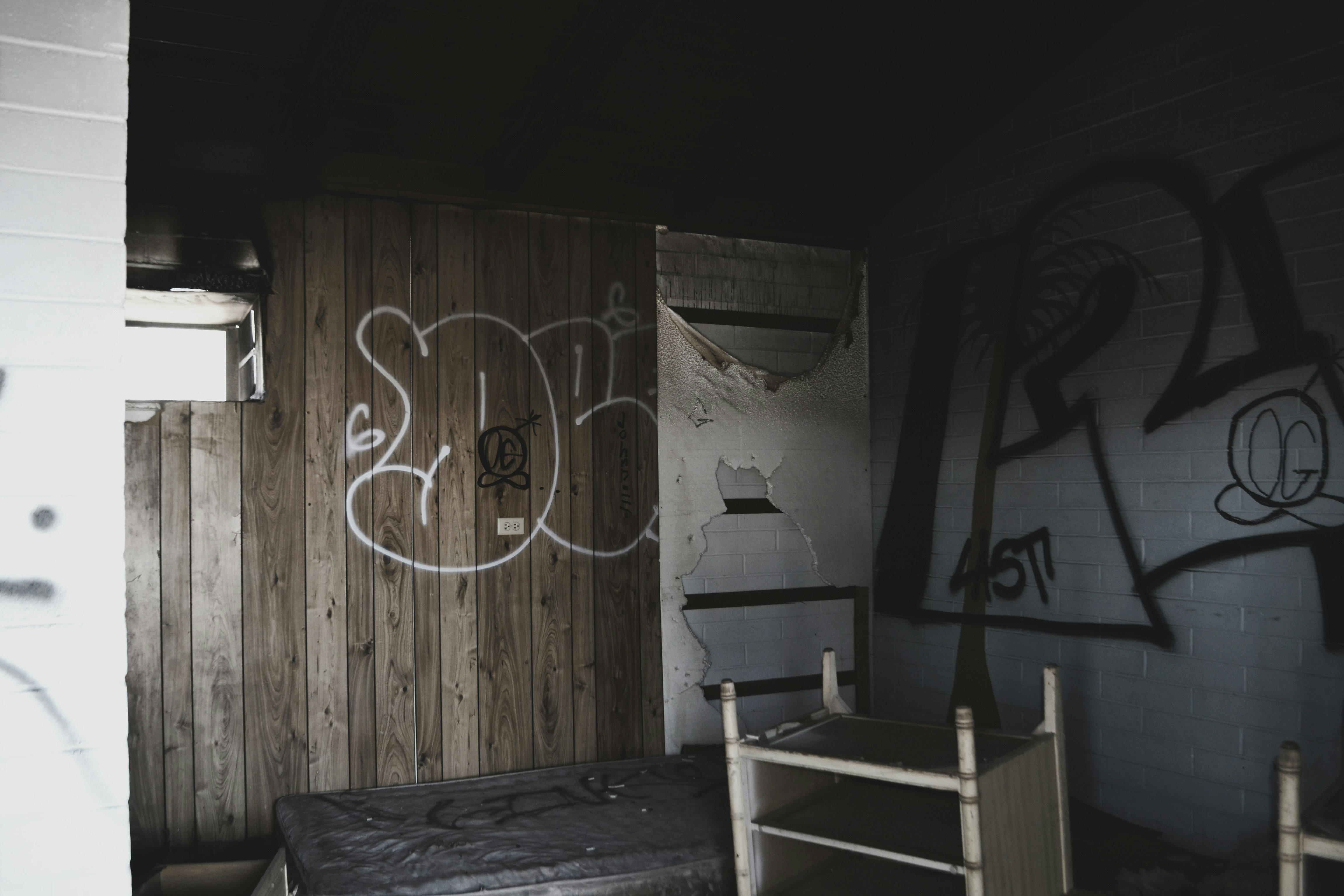 Graffiti Chamber: Weathered Wood, Concrete, and Shadowed Corners
