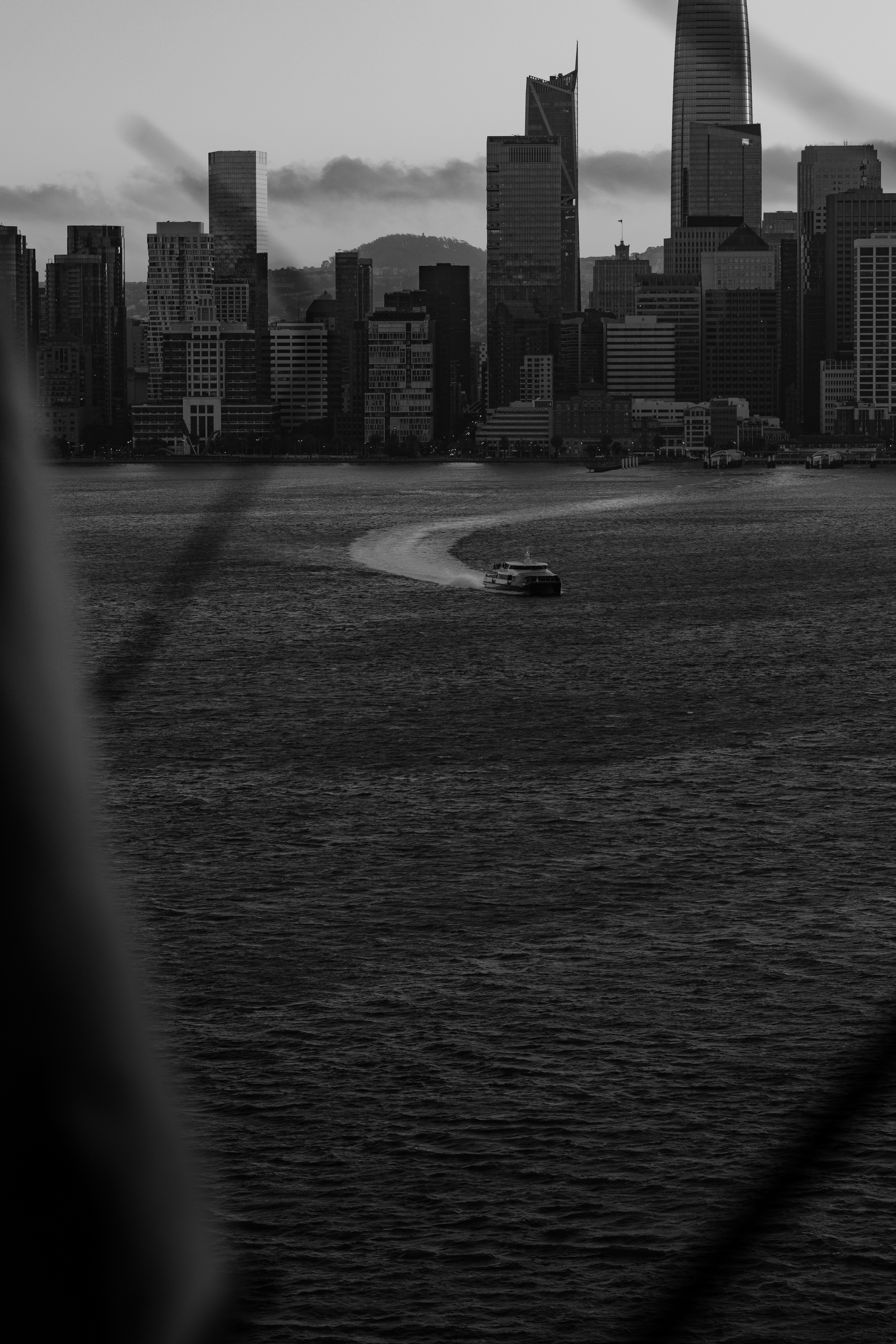 Boat Arcing Through the Harbor Toward the Skyline