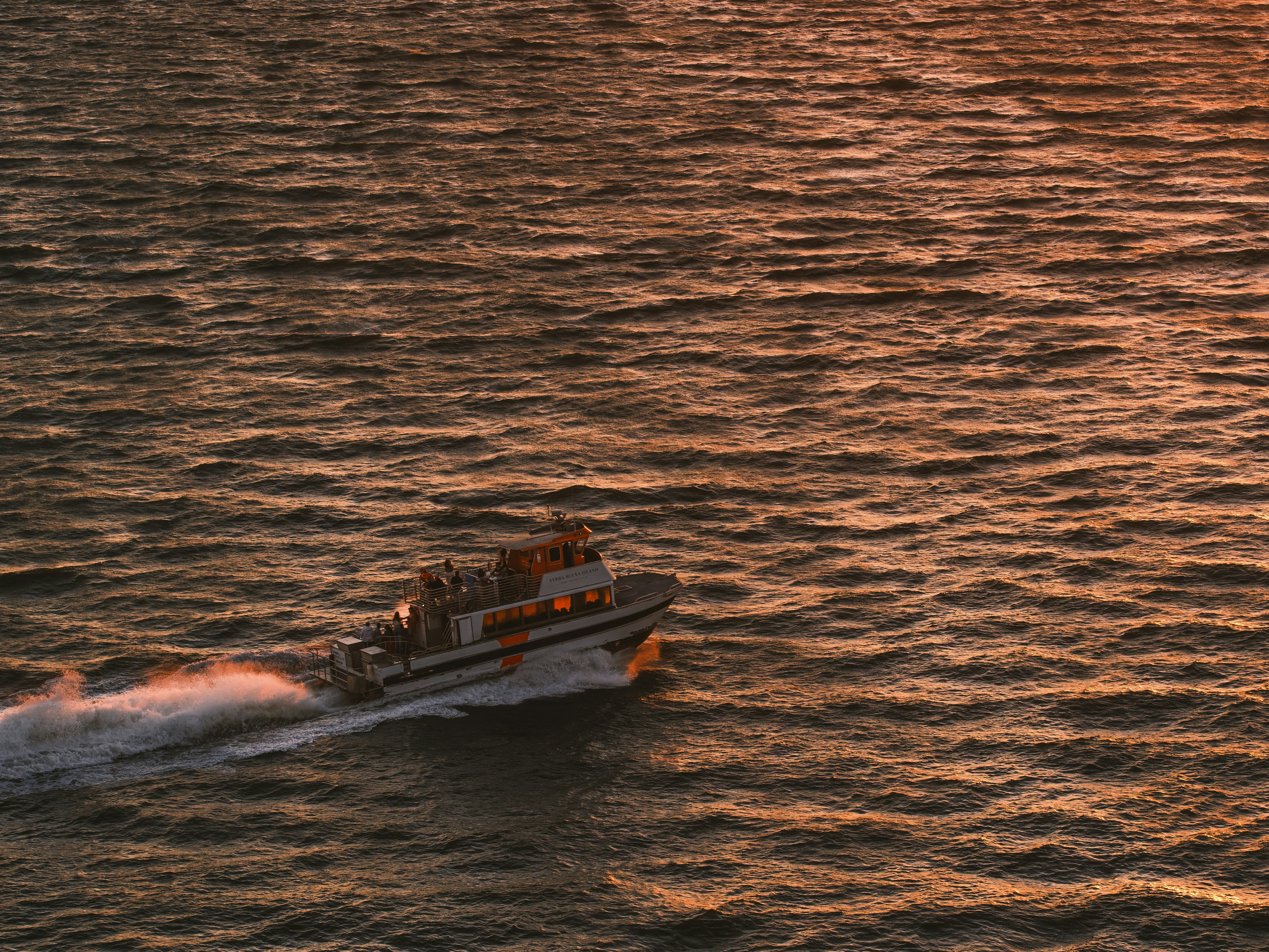 Sunset Run: A Coastline Ferry Cuts Through Copper-Tinted Waves