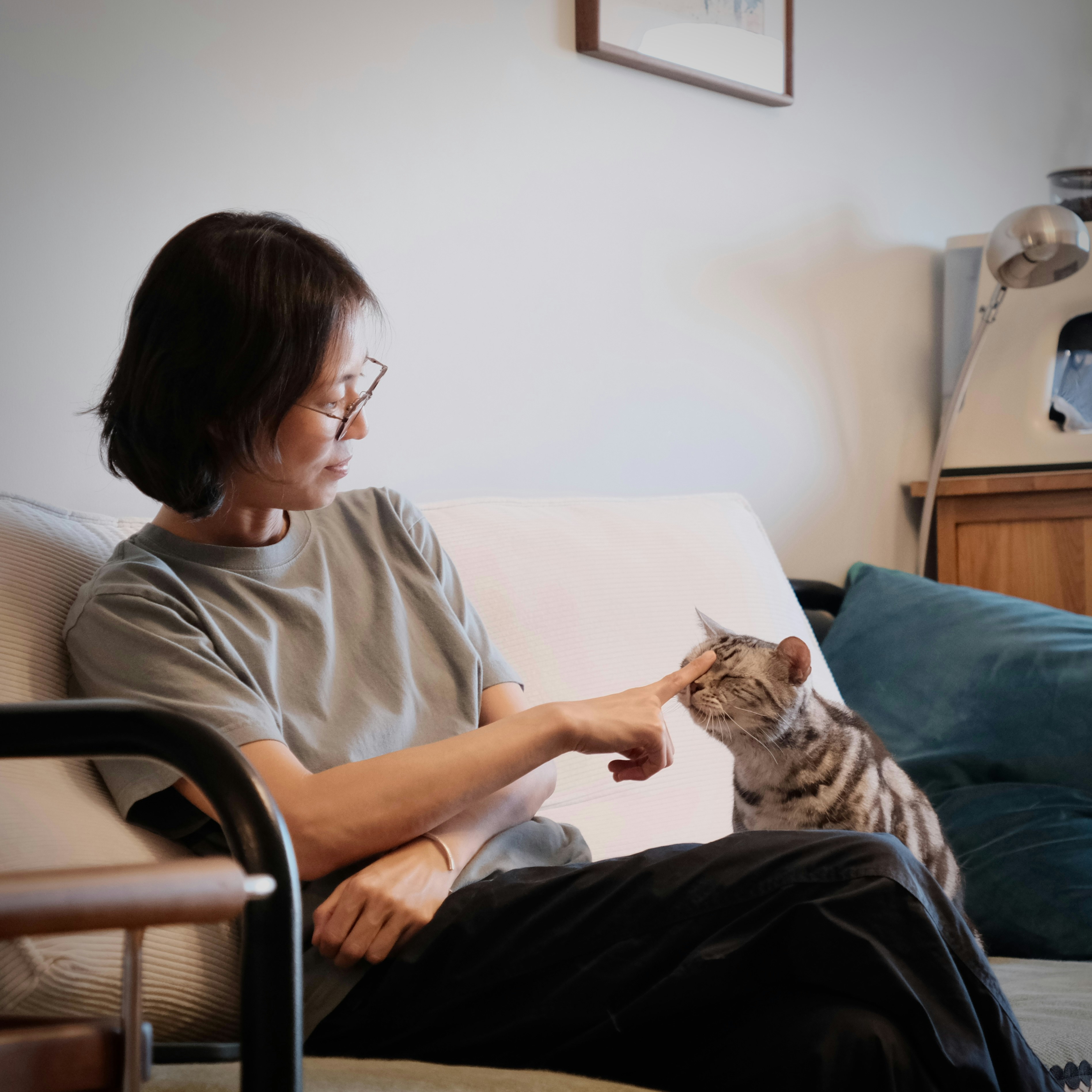 Gentle Exchange: Woman and Cat Share a Quiet Moment on the Sofa