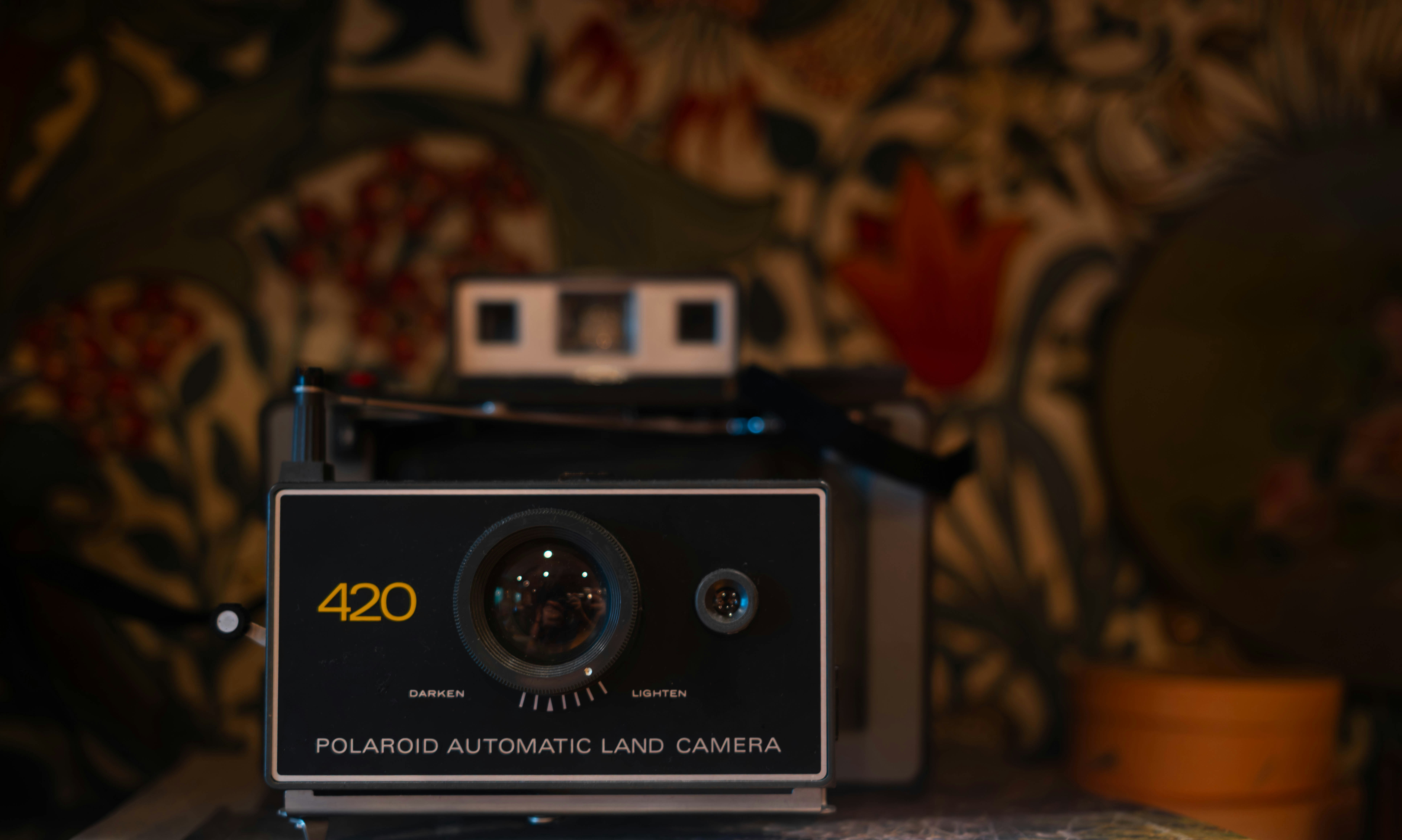 Polaroid Pioneer in a Dim Studio: A Retro Camera Resting on a Wooden Shelf