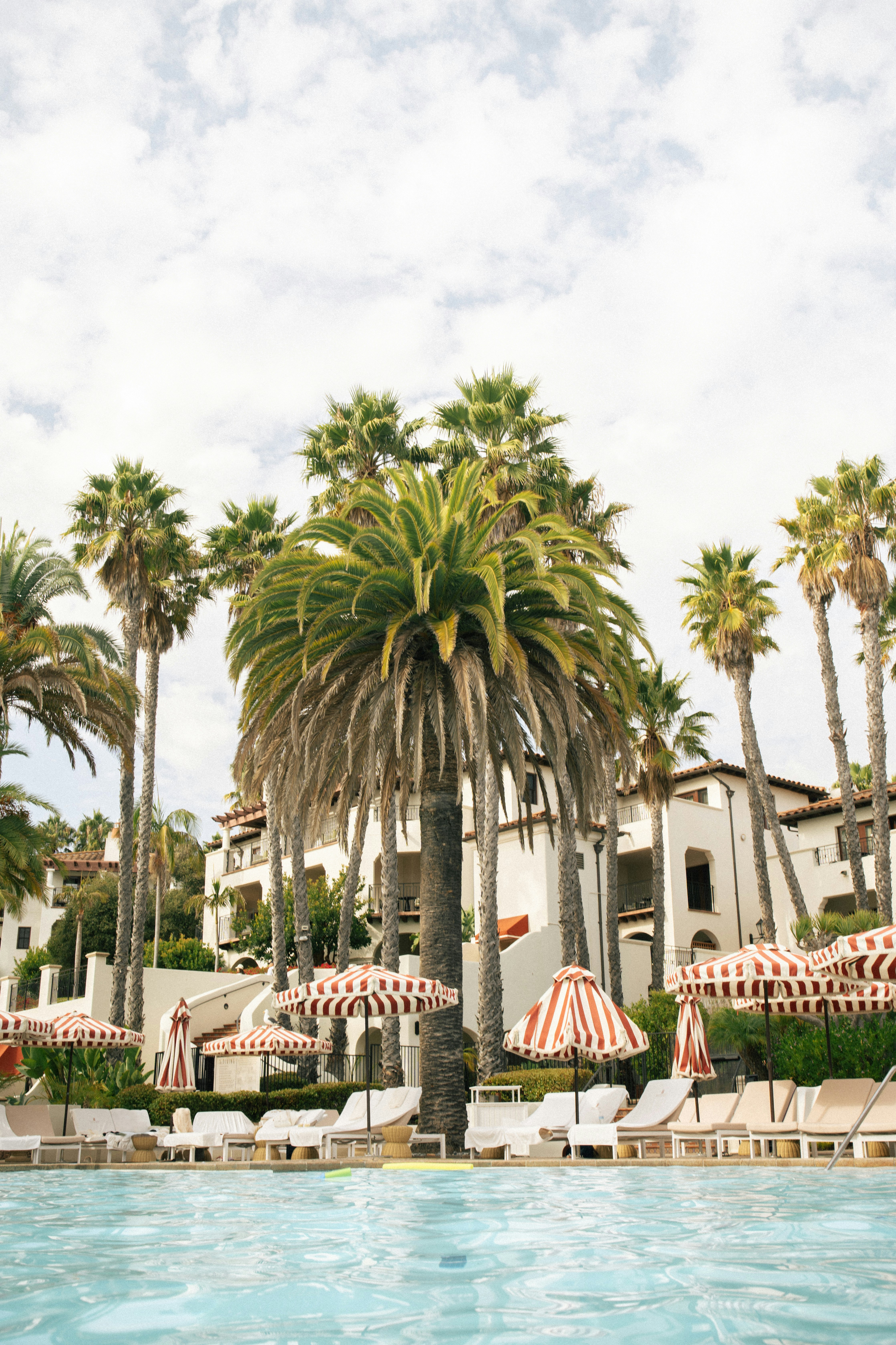Palm Oasis by the Pool: Sunset Amidst Striped Canopies