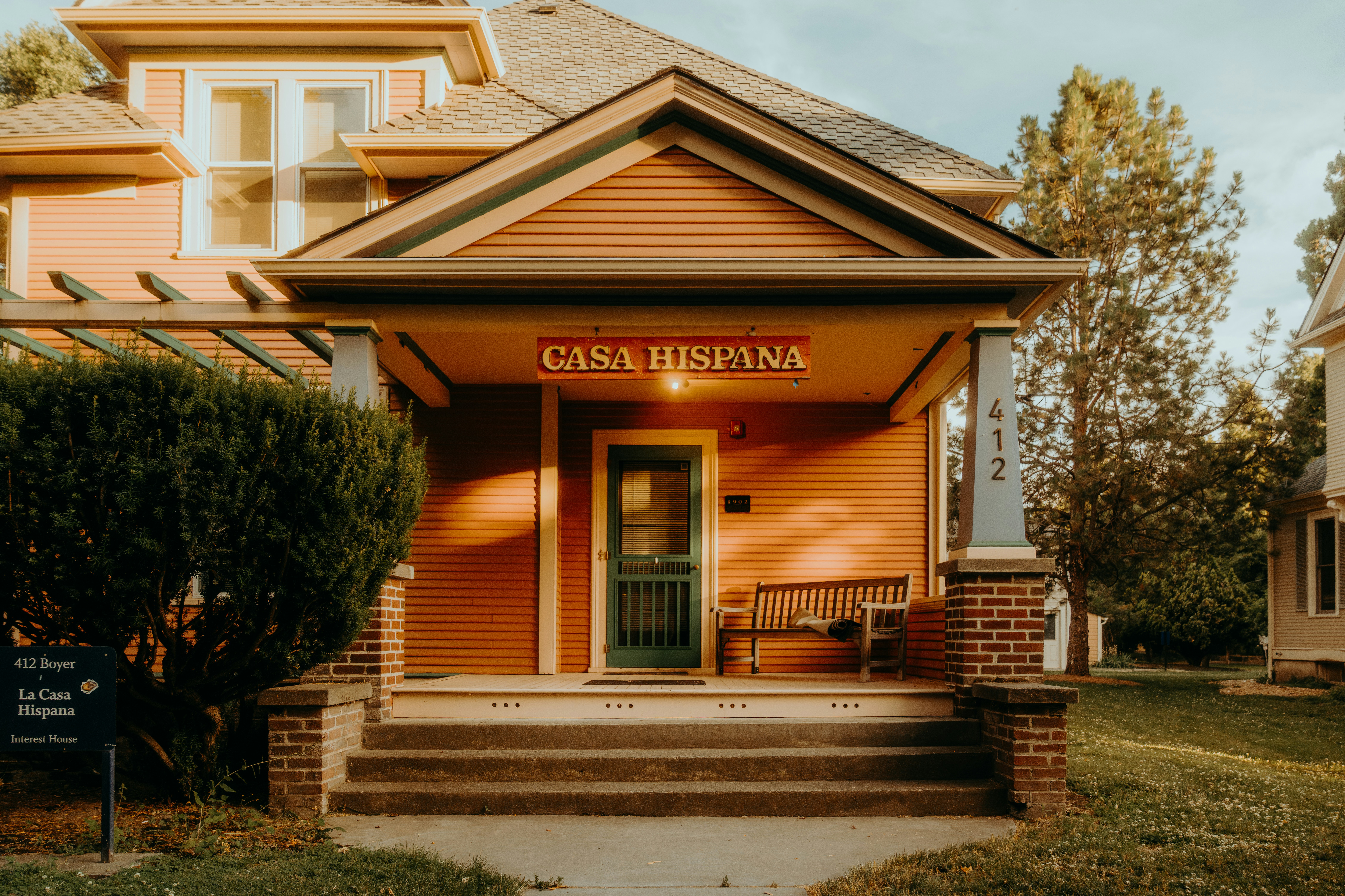 Casa Hispana Facade: Warm Porch Light on a Charred Orange House