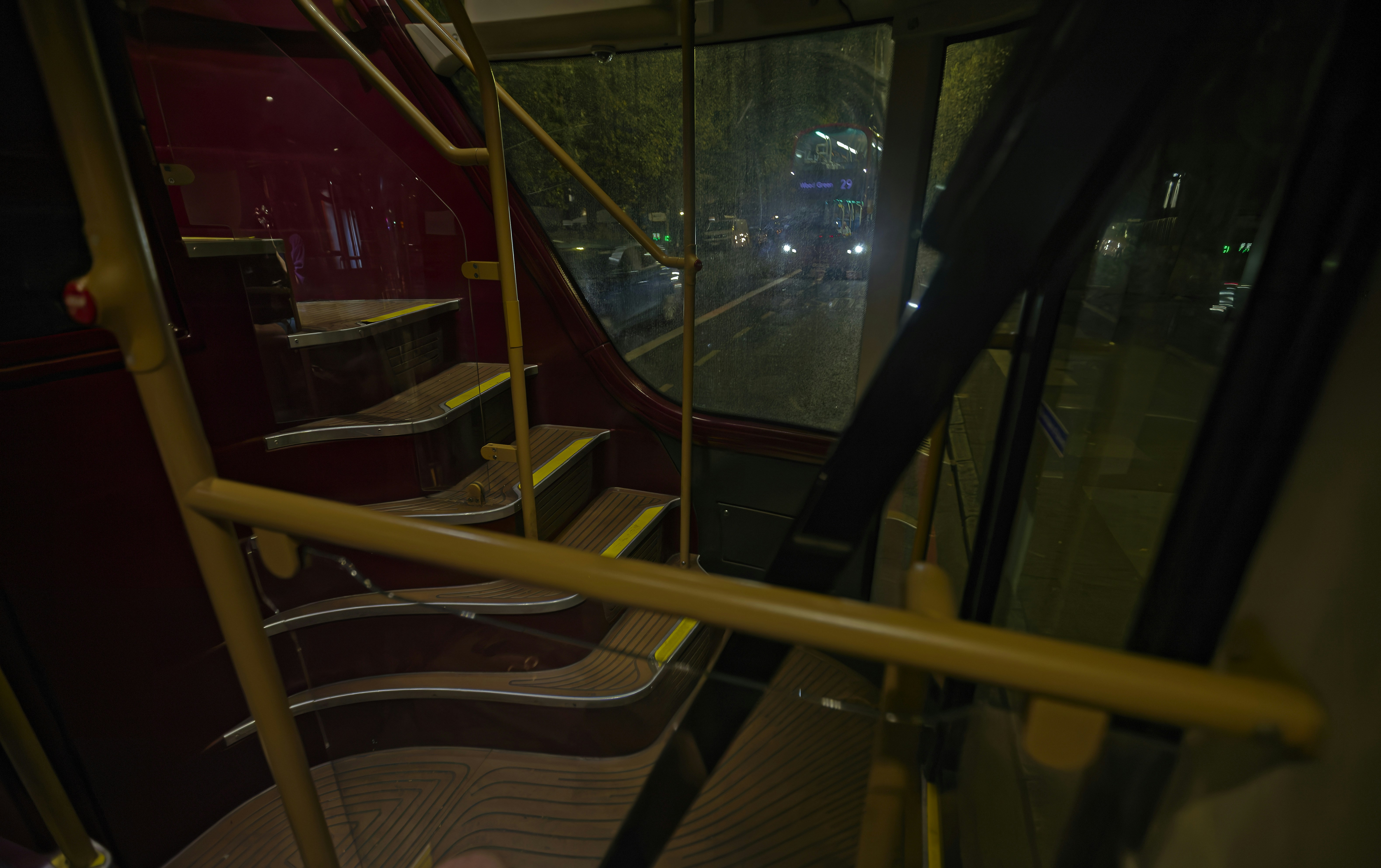 Nocturne in a Bus Cabin: Railings and Reflections in Dim Neon