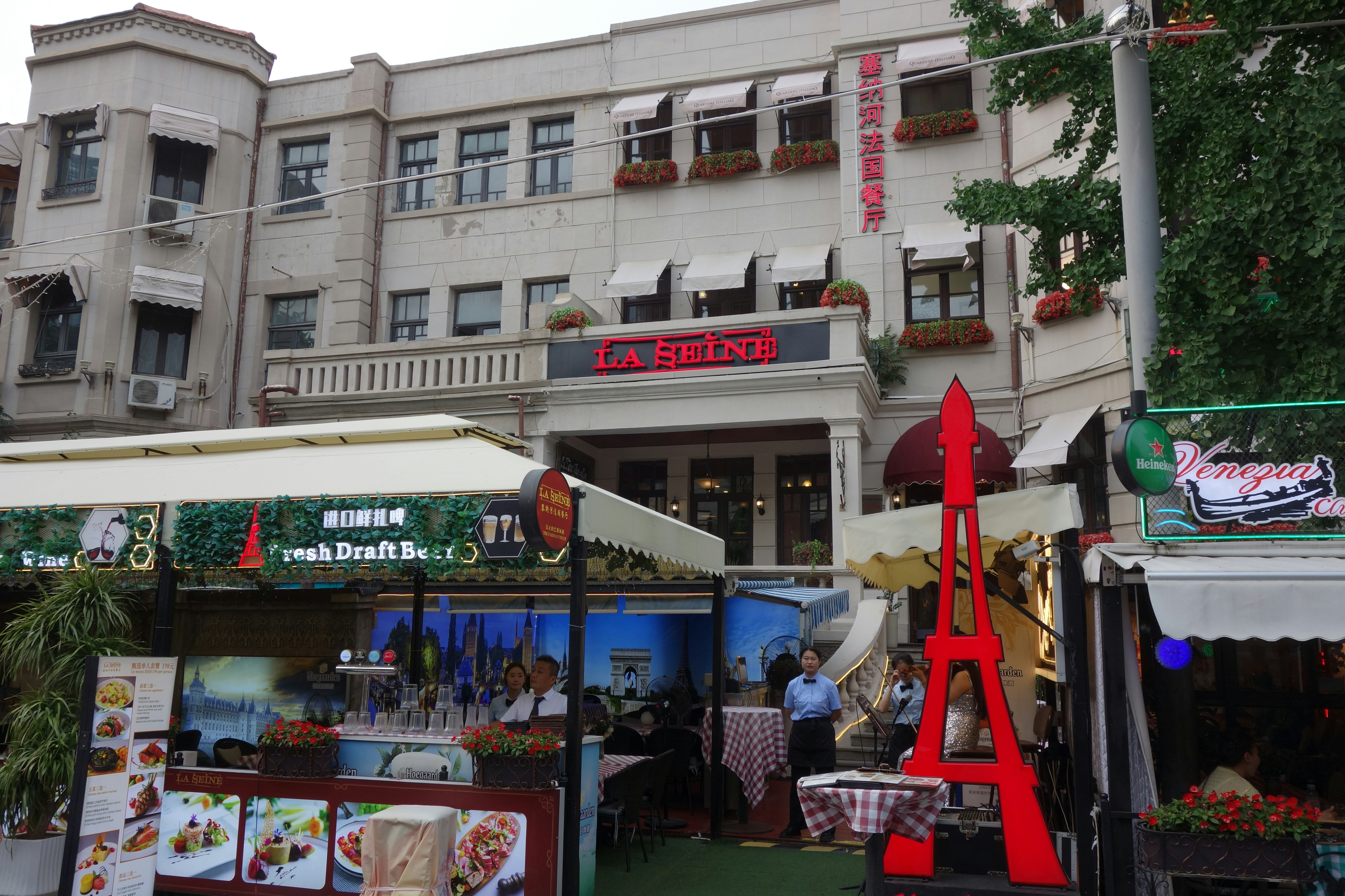 Cafe Terrace Frontage with Red Arrow Sculpture under Awned Building