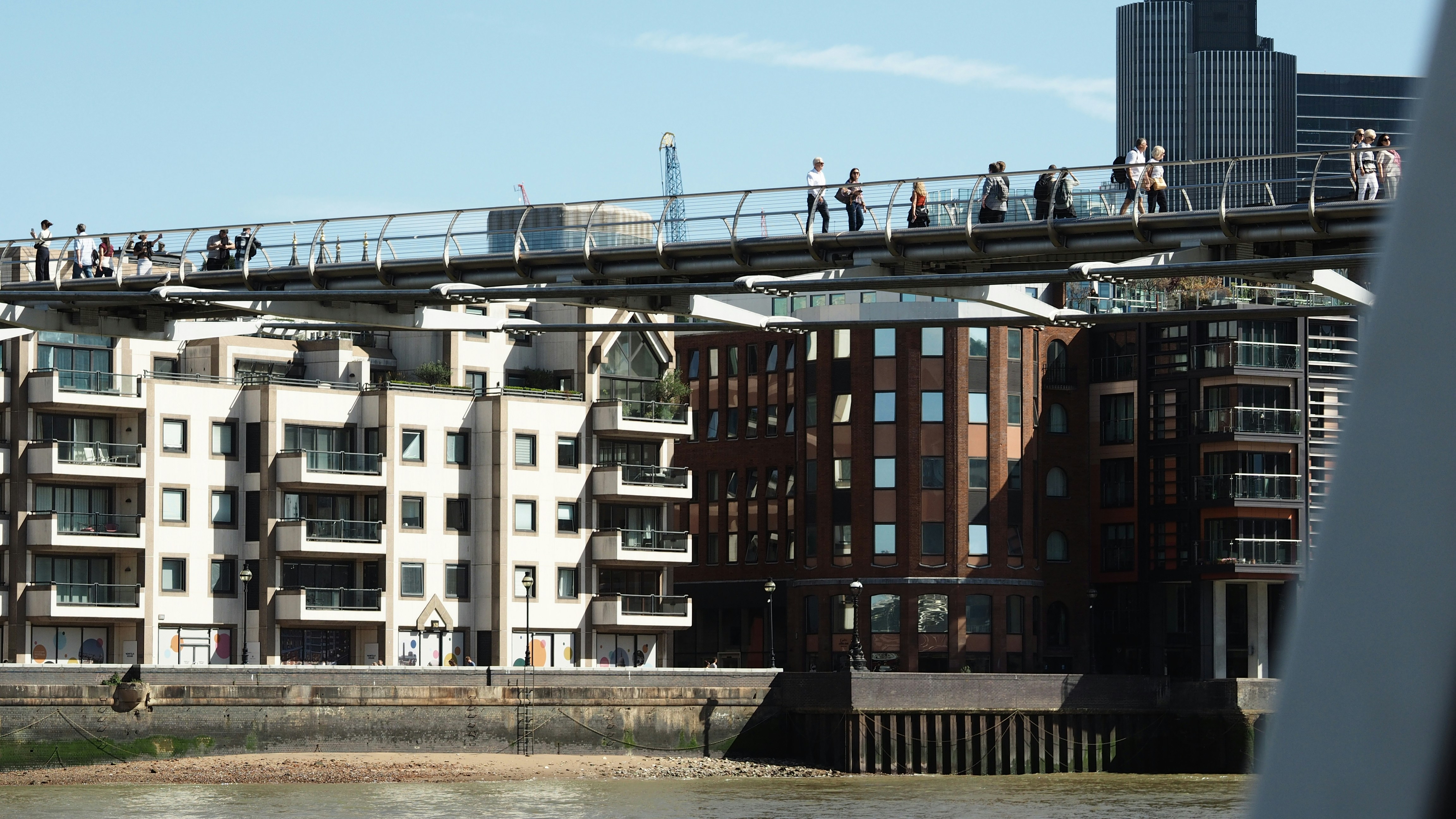 Pedestrian Bridge over a River: Cityscape in Motion