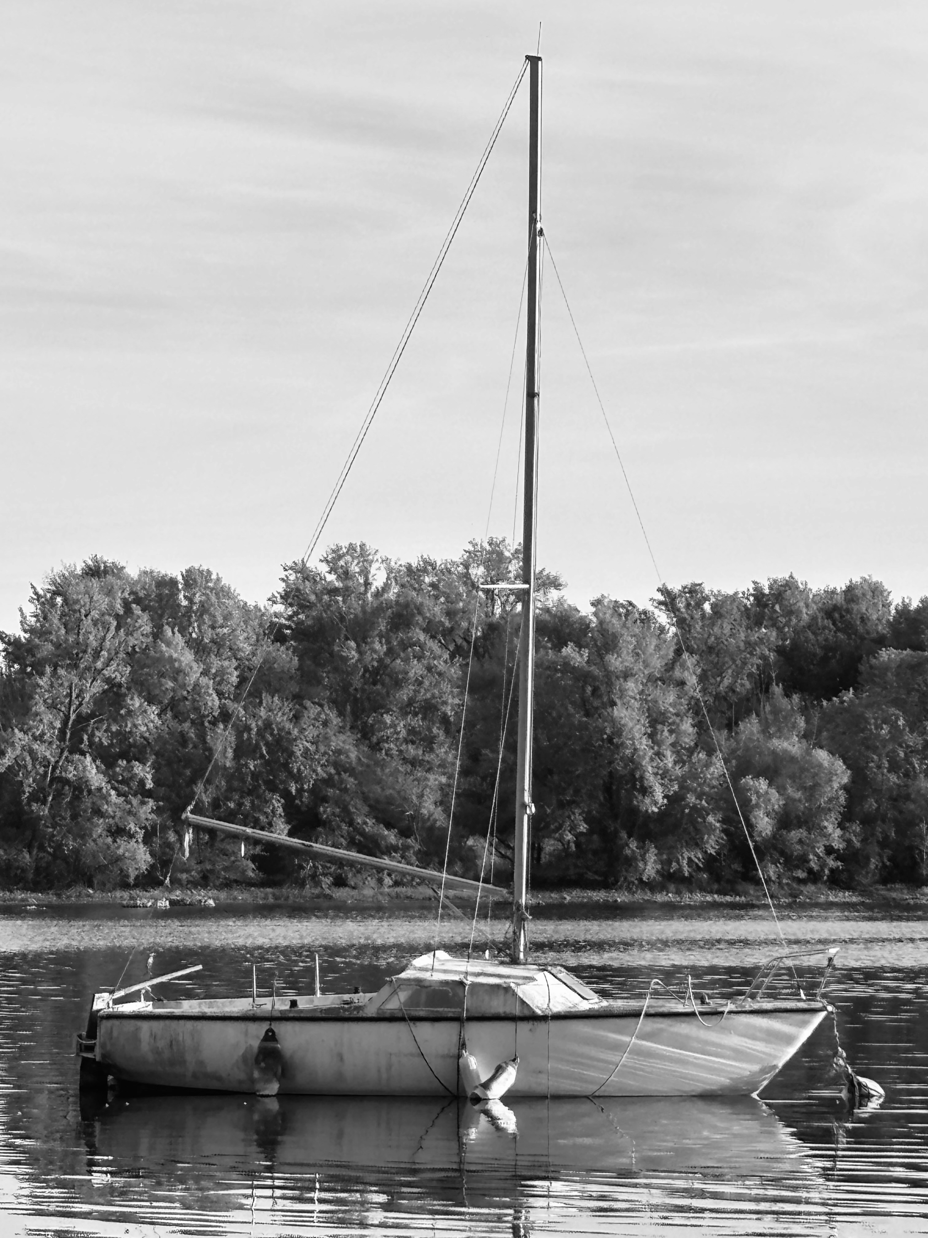 Sailboat Resting on Mirror-like Lake at Dusk