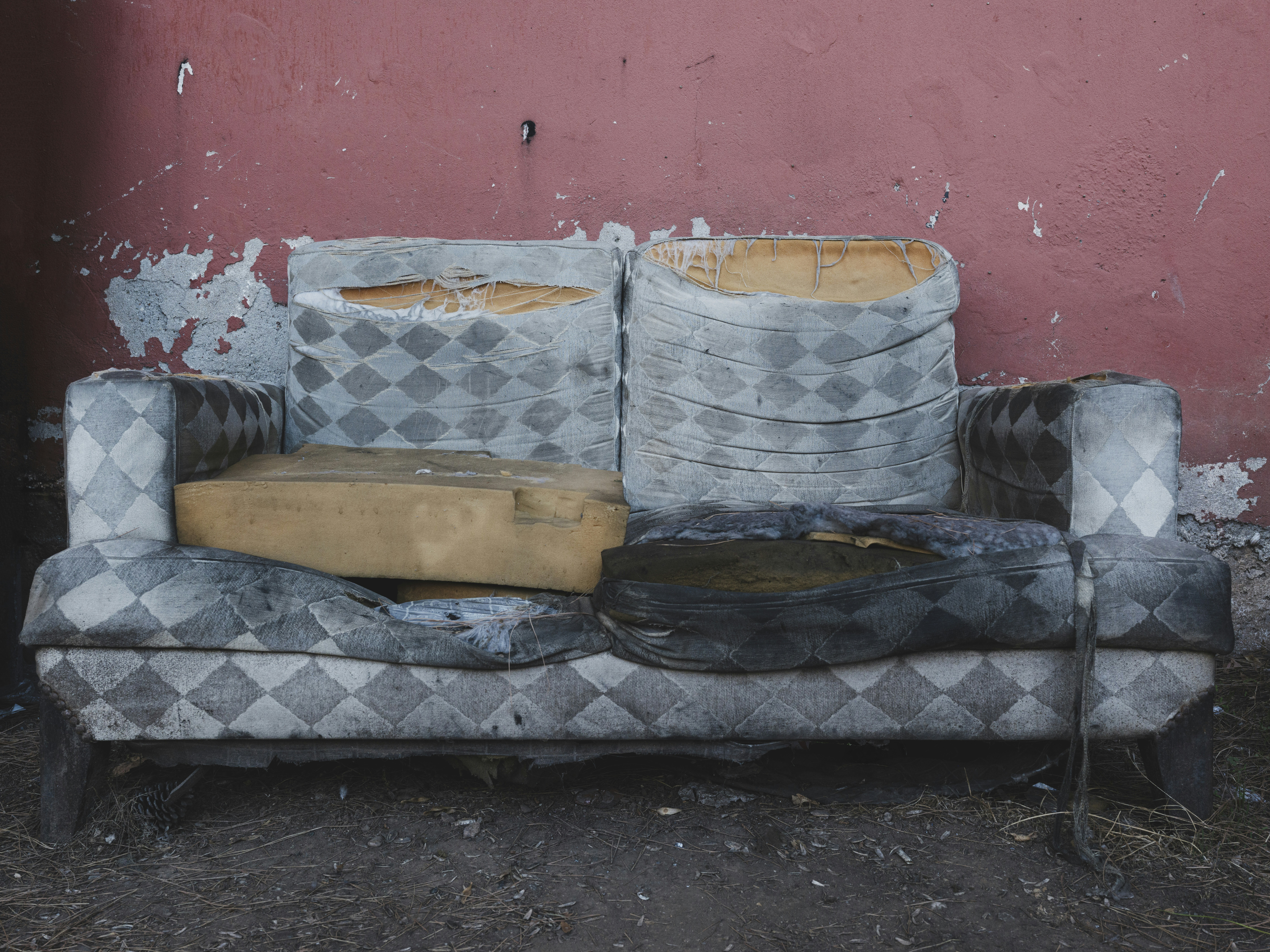 Damaged retro armchair in an outdoor scrap yard