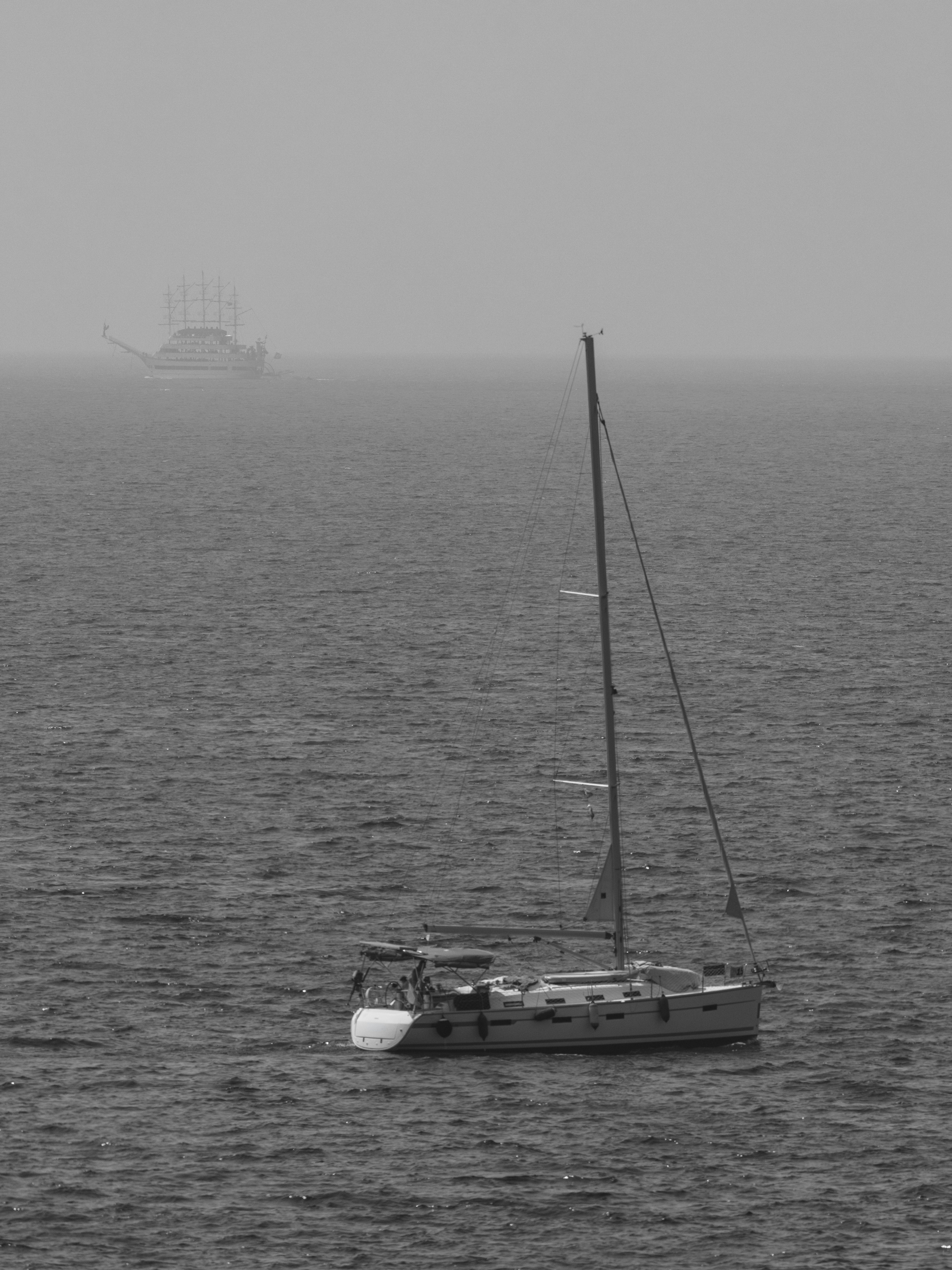 Misty Sailboat Amid Distant Carrier Horizon