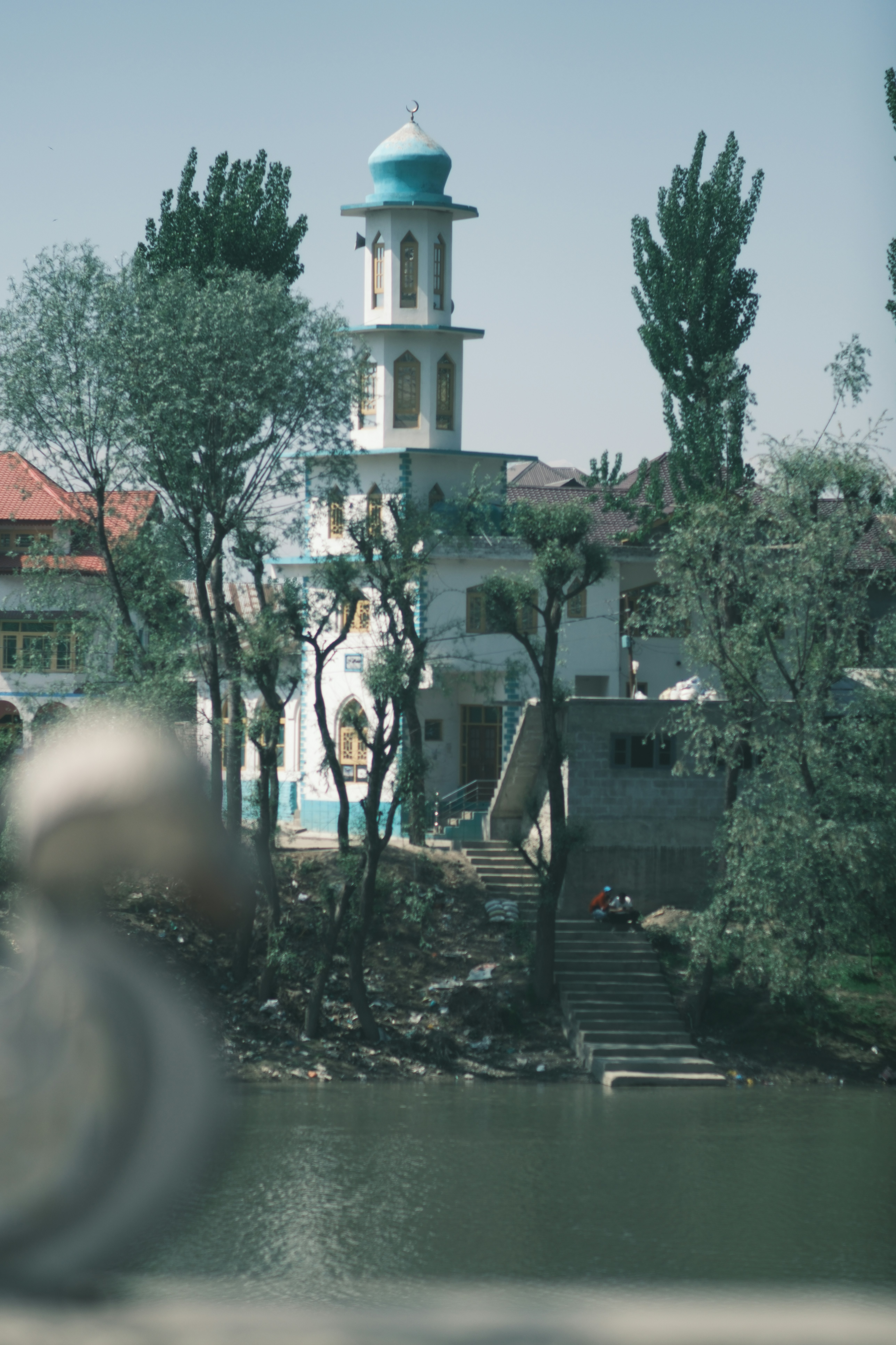 Turquoise Minaret Rising Over Riverside Trees