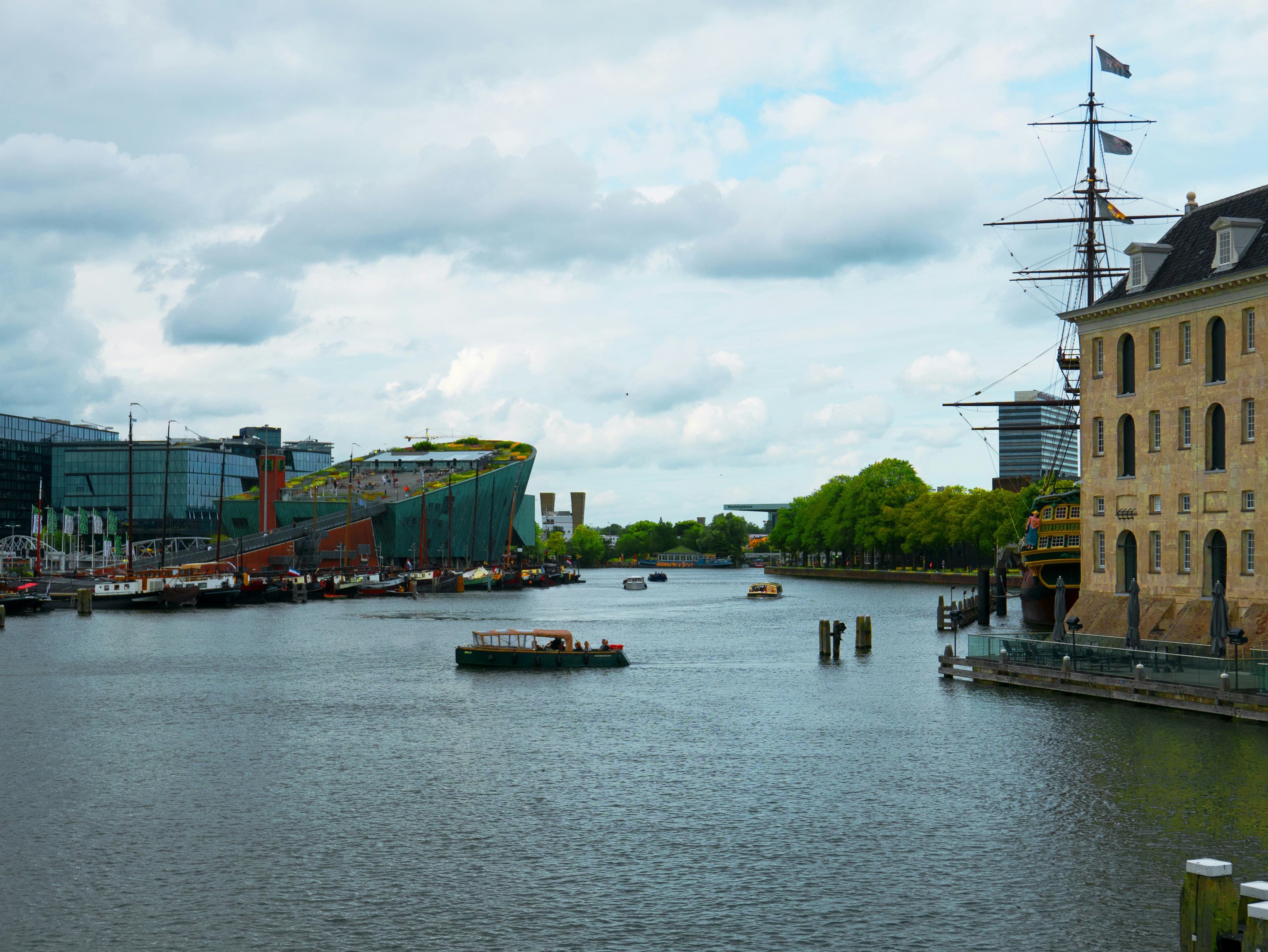 Harbor Portrait: Brick Warehouse and Sailing Ship Docked Along the River