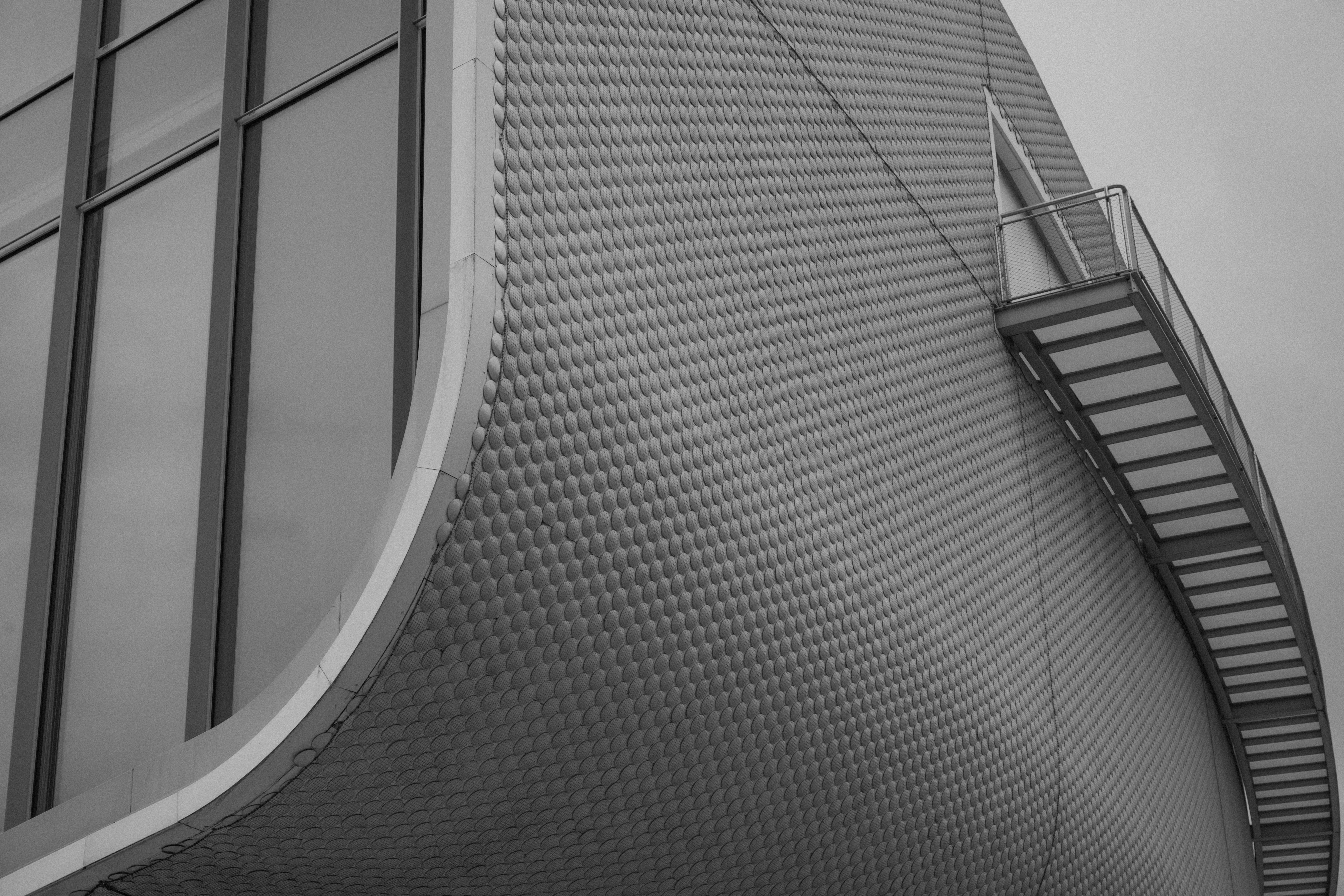 Curved Facade Rhythm: Grainy Metal and Glass Along a Narrow Stair