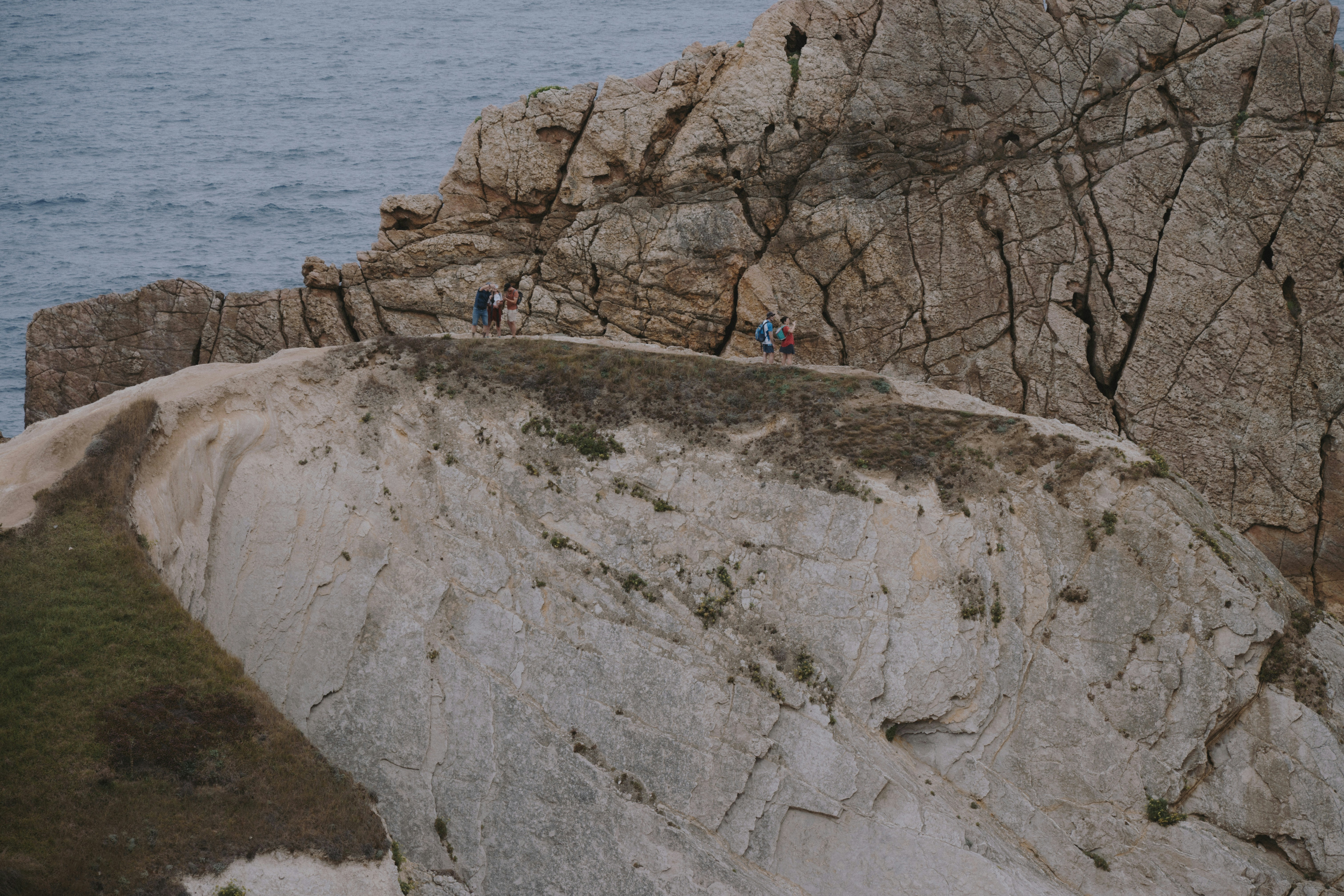 Cliffside View with Small Human Figures near Weathered Limestone