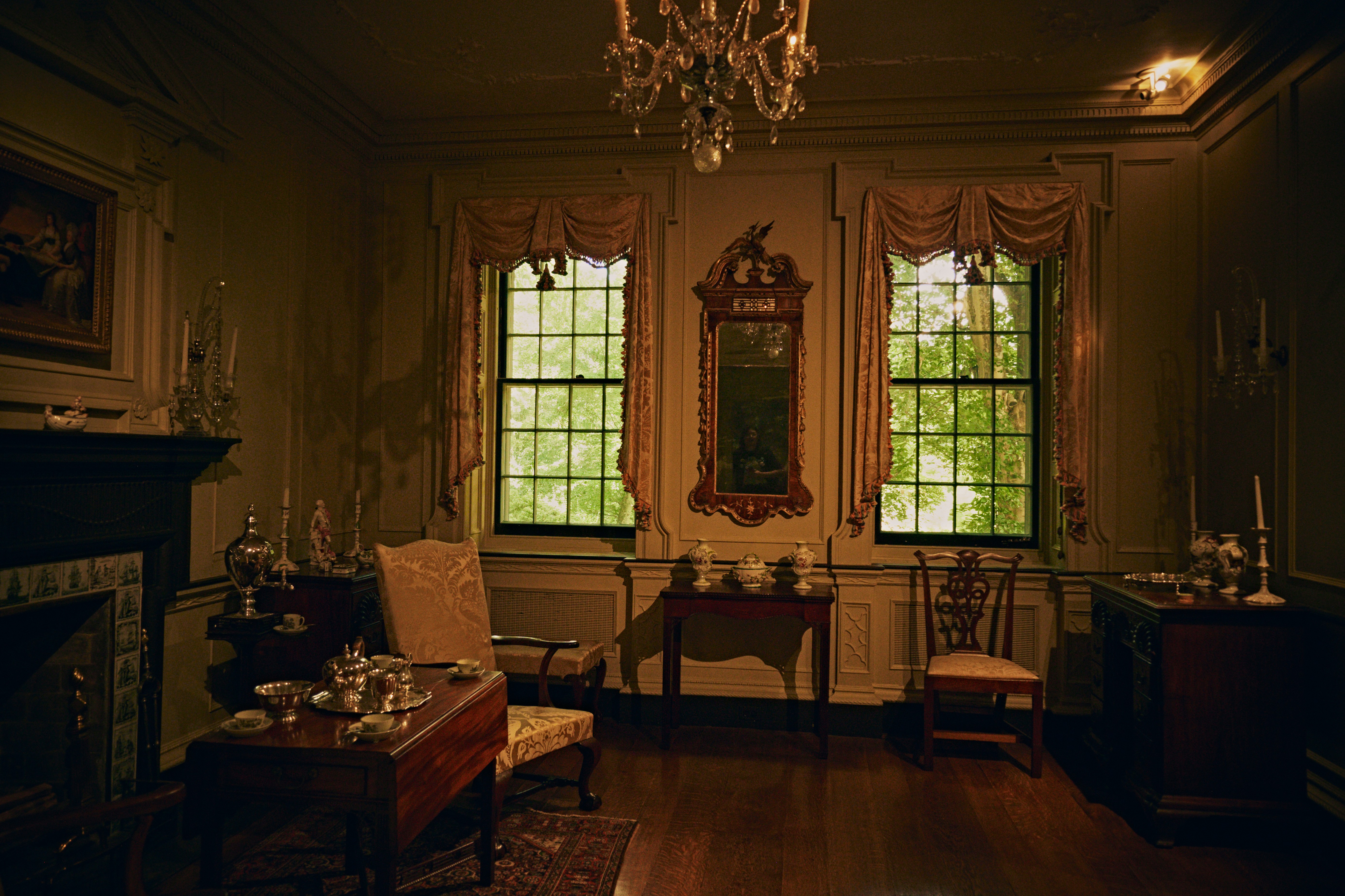 Dimly Lit Victorian Parlor with Ornate Mirror and Green Glass