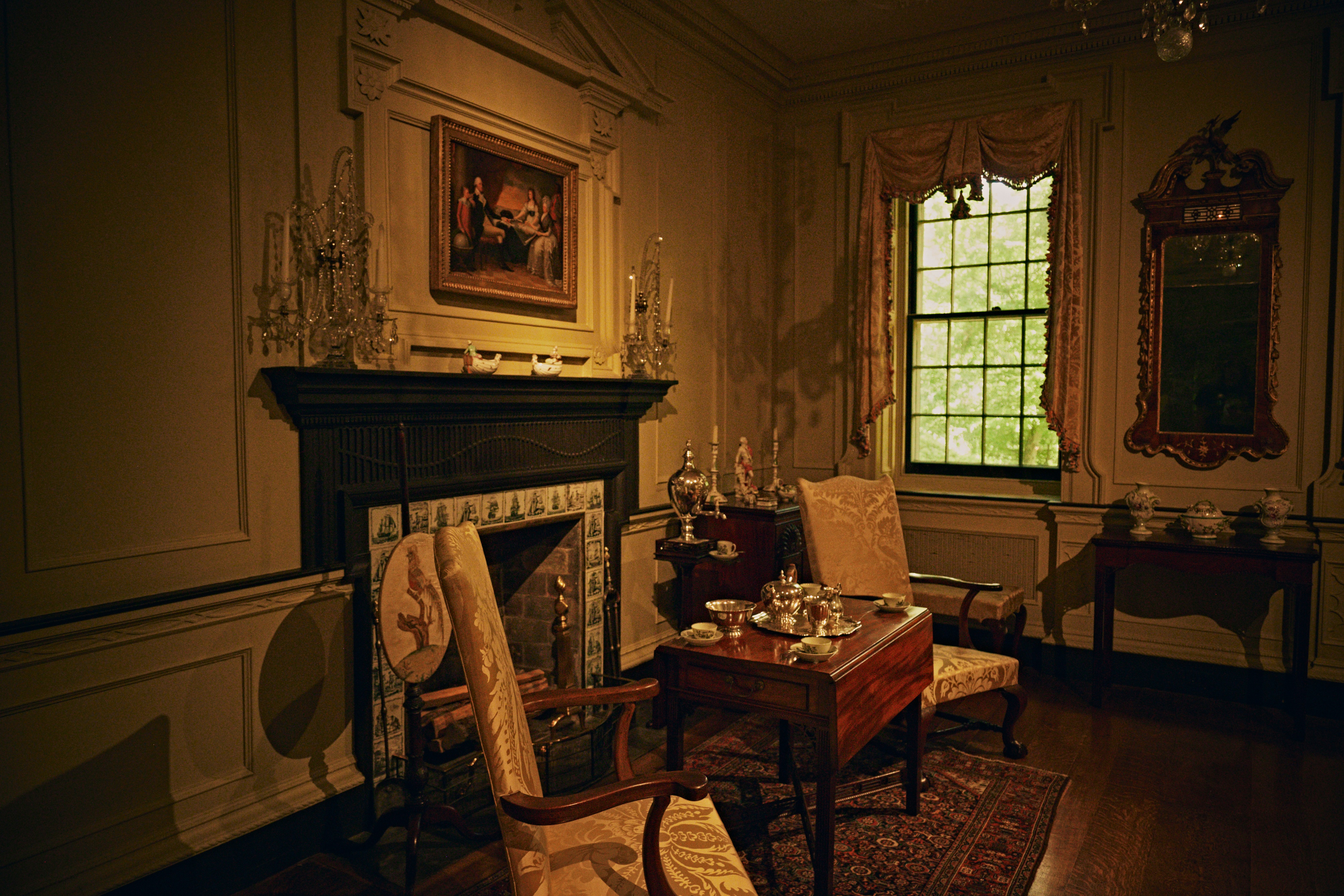 Dimly Lit Parlour with Teatime still-life beneath a Painted Fireplace