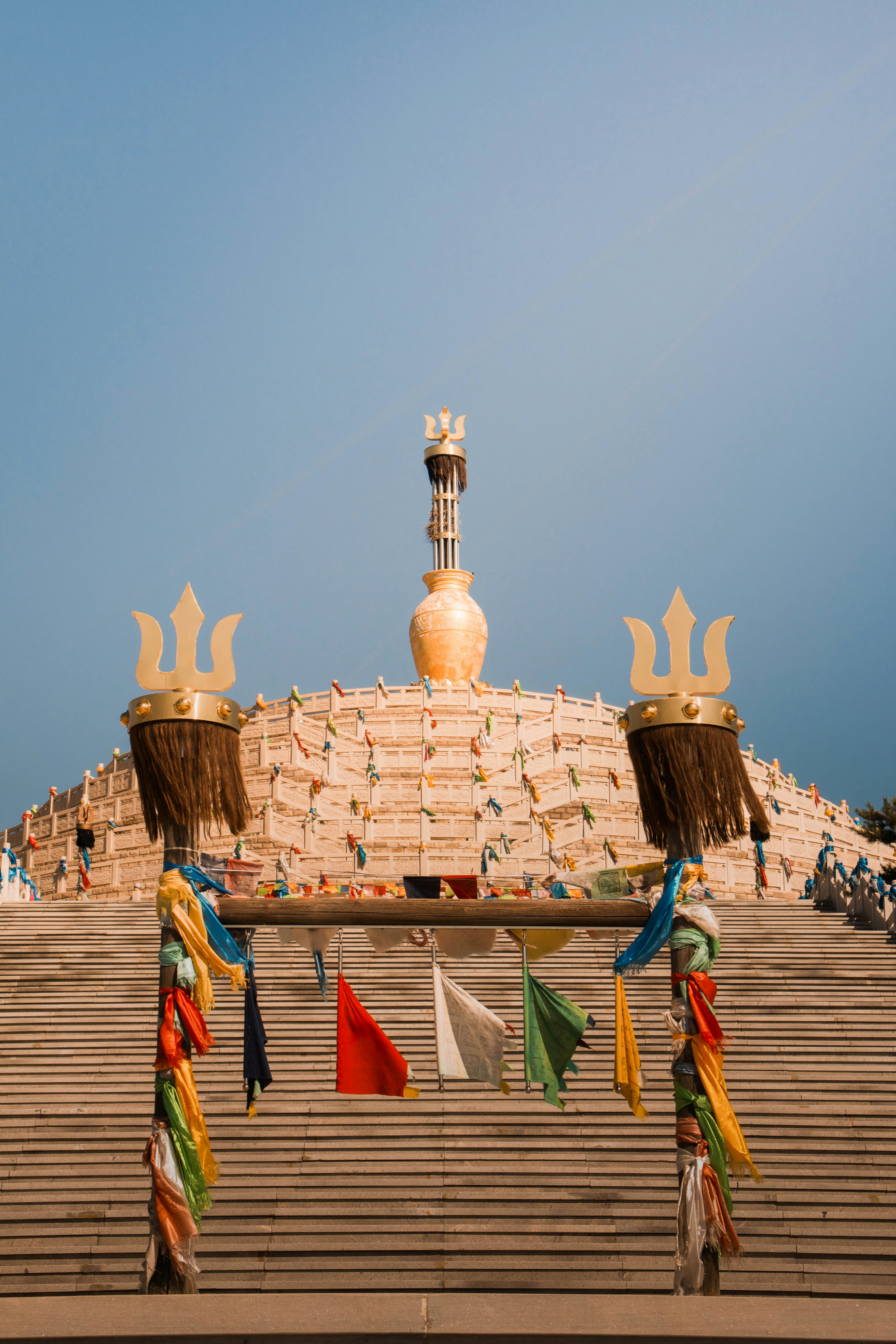 Golden Summit: Prayer Flags and Topped Spire Rise Above Sacred Steps