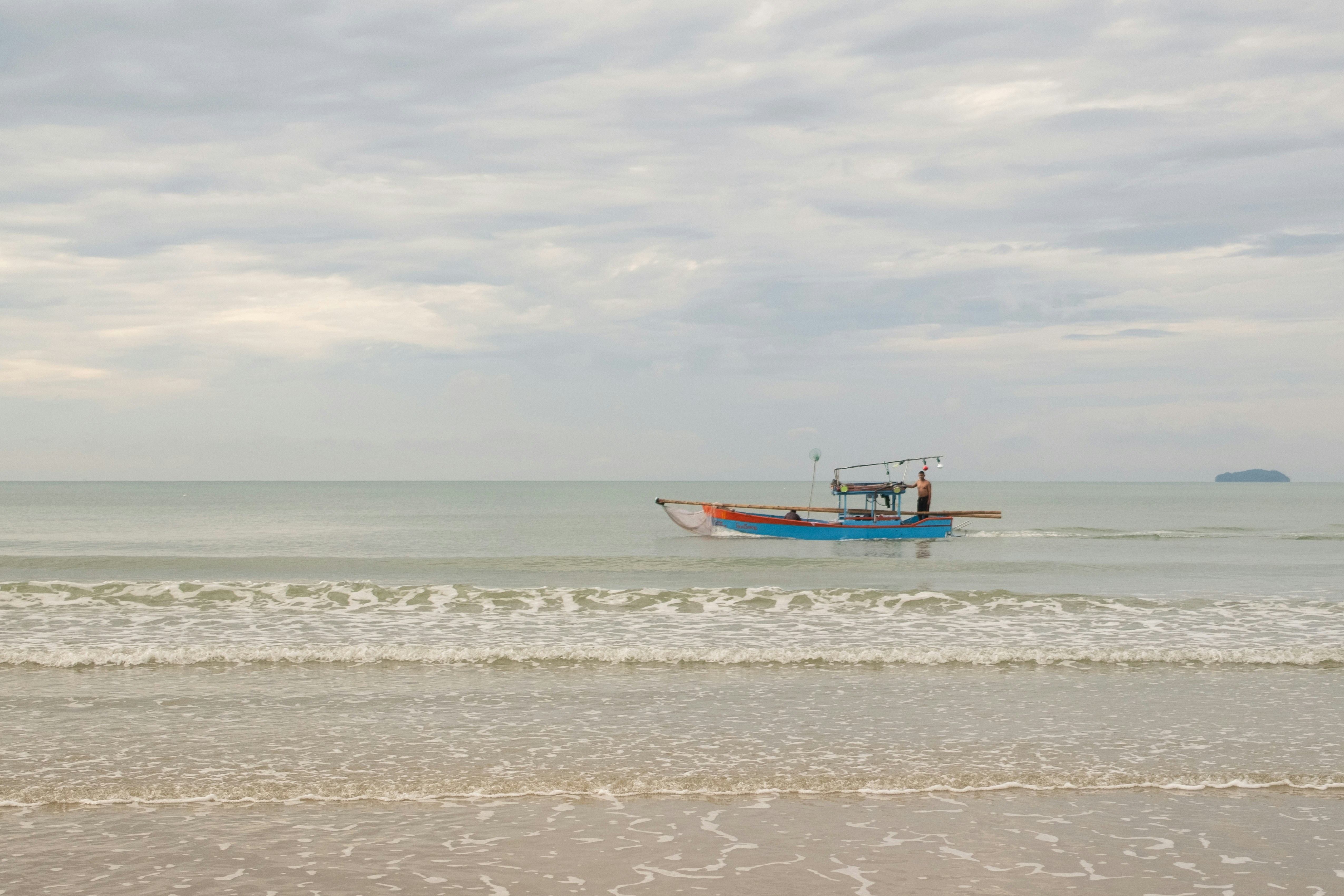 Blue-Trim Boat Drifts Across a Quiet Seascape